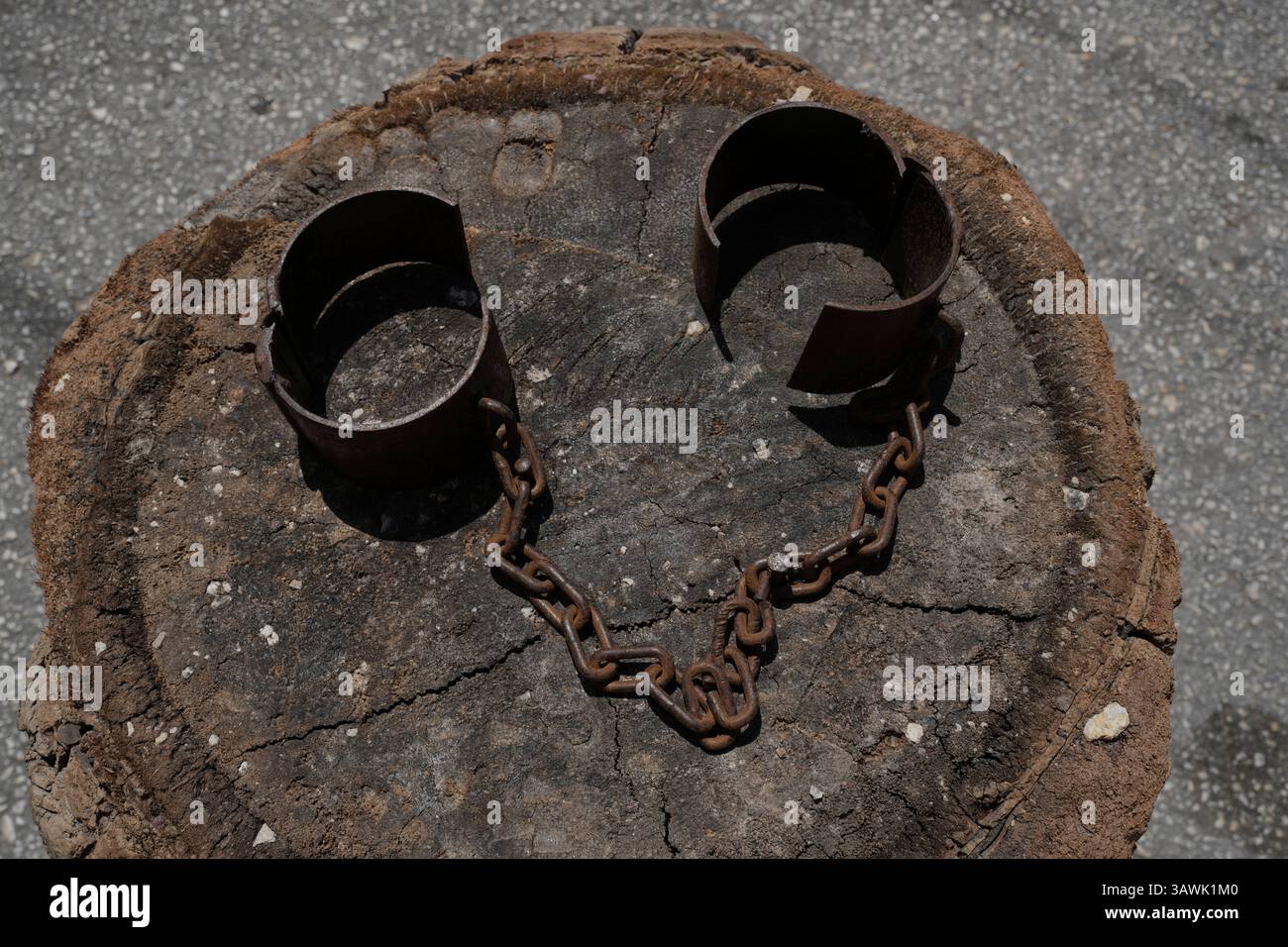 Rusty shackles rest on a tree stump as part of a Good Friday observance ...