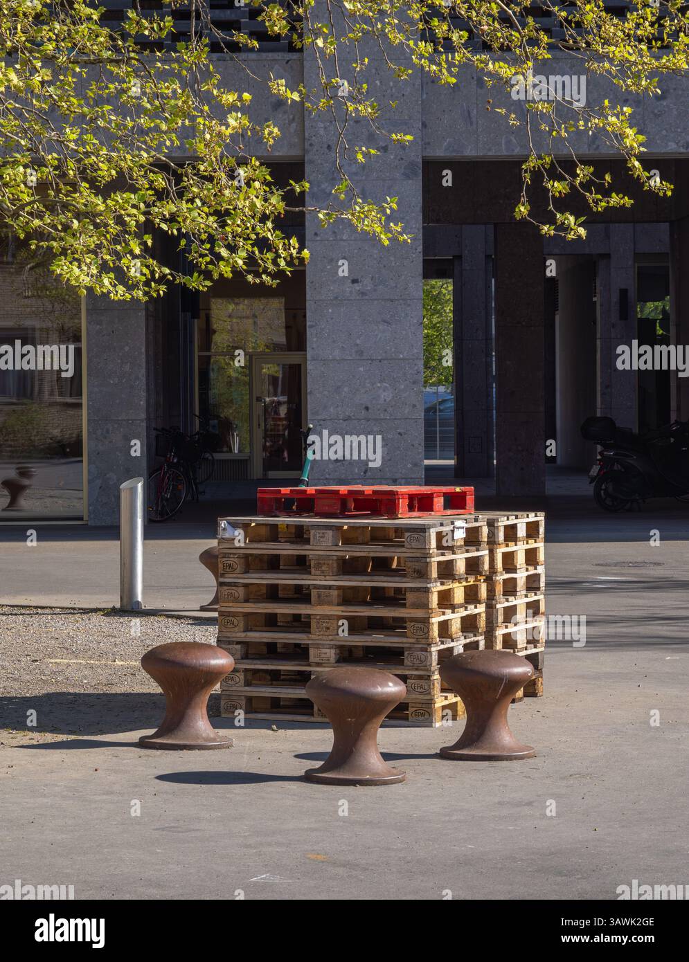 Outdoor seating area in Zurich with stacked wooden pallets and round ...