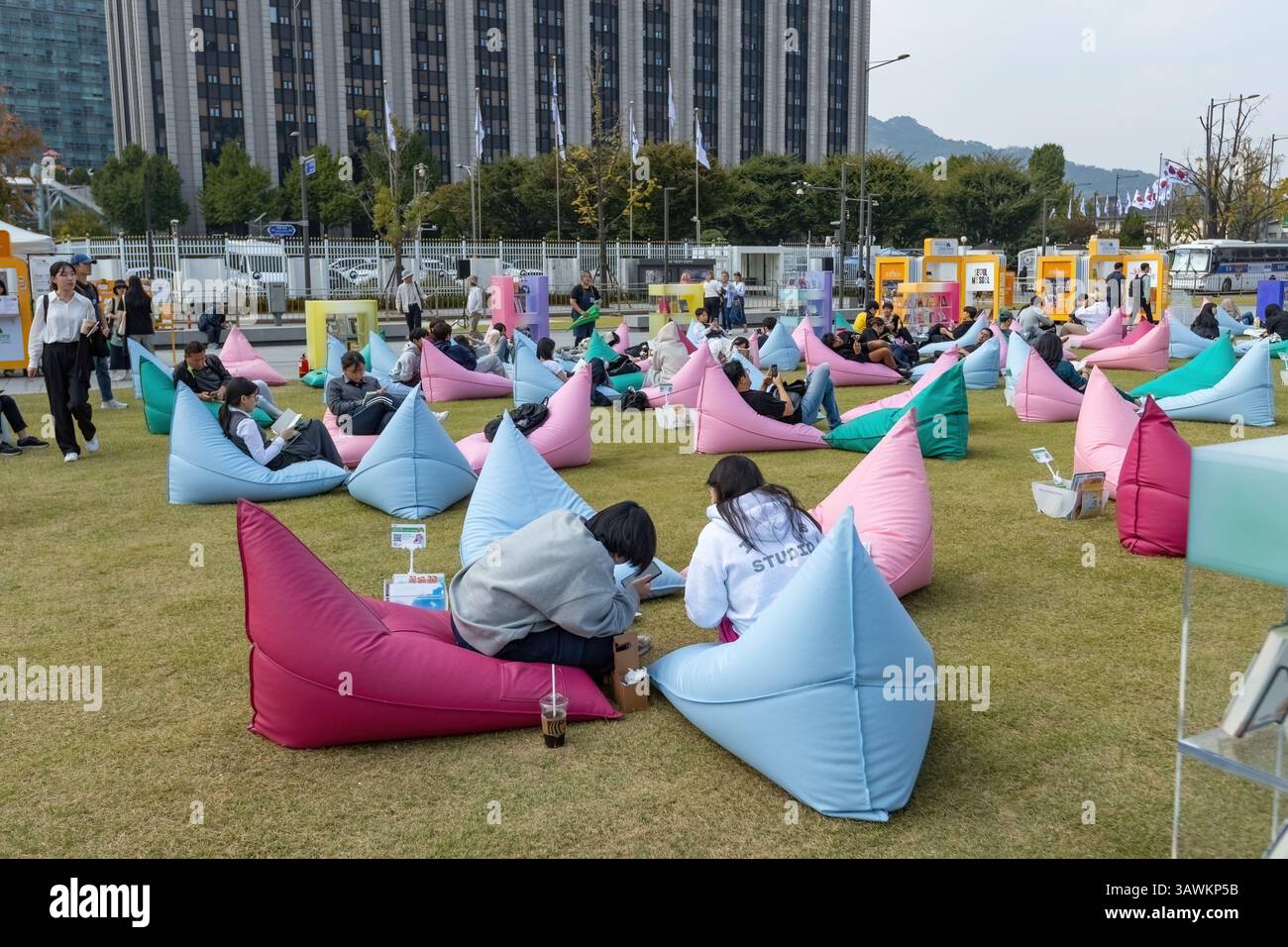 Outdoor library on the green lawn people sitting and reading books on ...