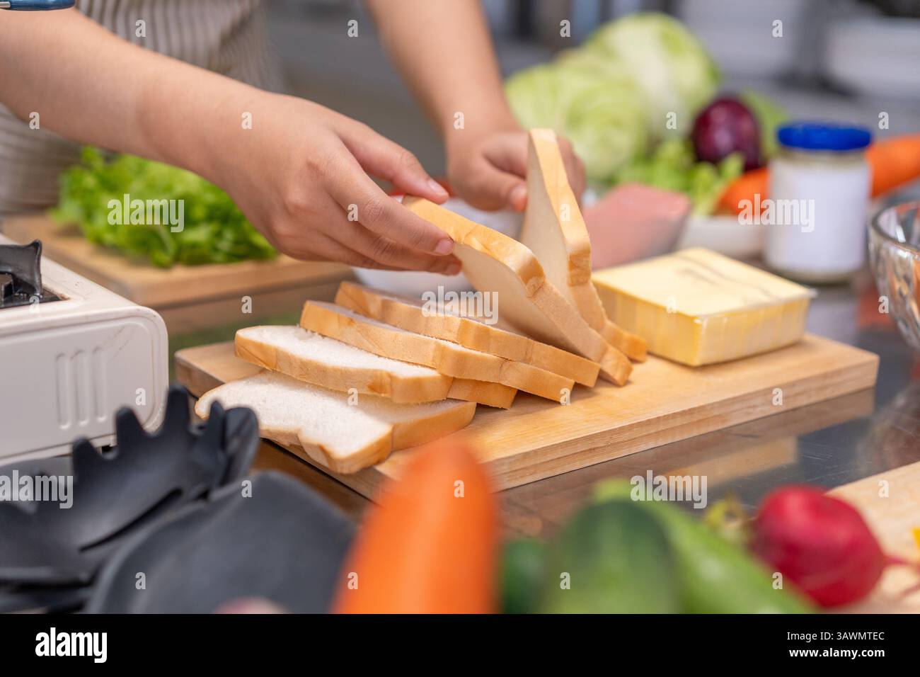Close-up hands of a Young Female Chef Preparing a Sandwich is seen ...