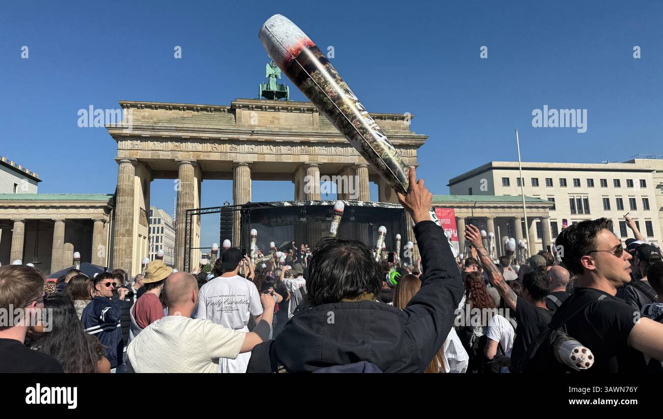 20 April 2025, Berlin: Numerous people stand with joints and giant ...