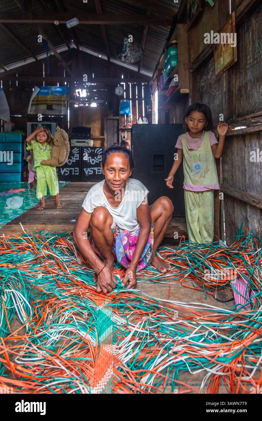 A Bajau woman in Bongao, Tawi-Tawi skillfully weaves a mat from pandan ...