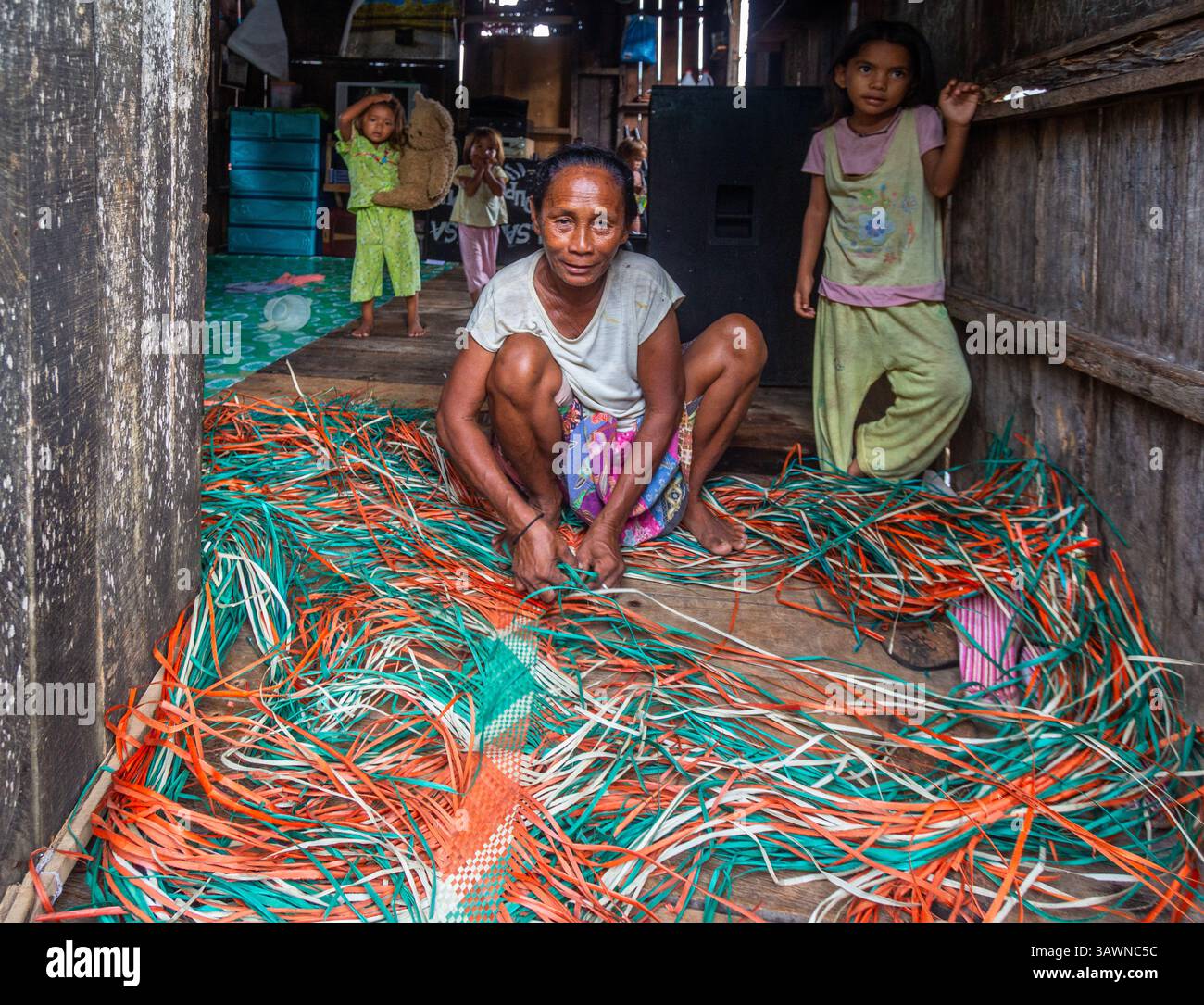 A Bajau woman in Bongao, Tawi-Tawi skillfully weaves a mat from pandan ...