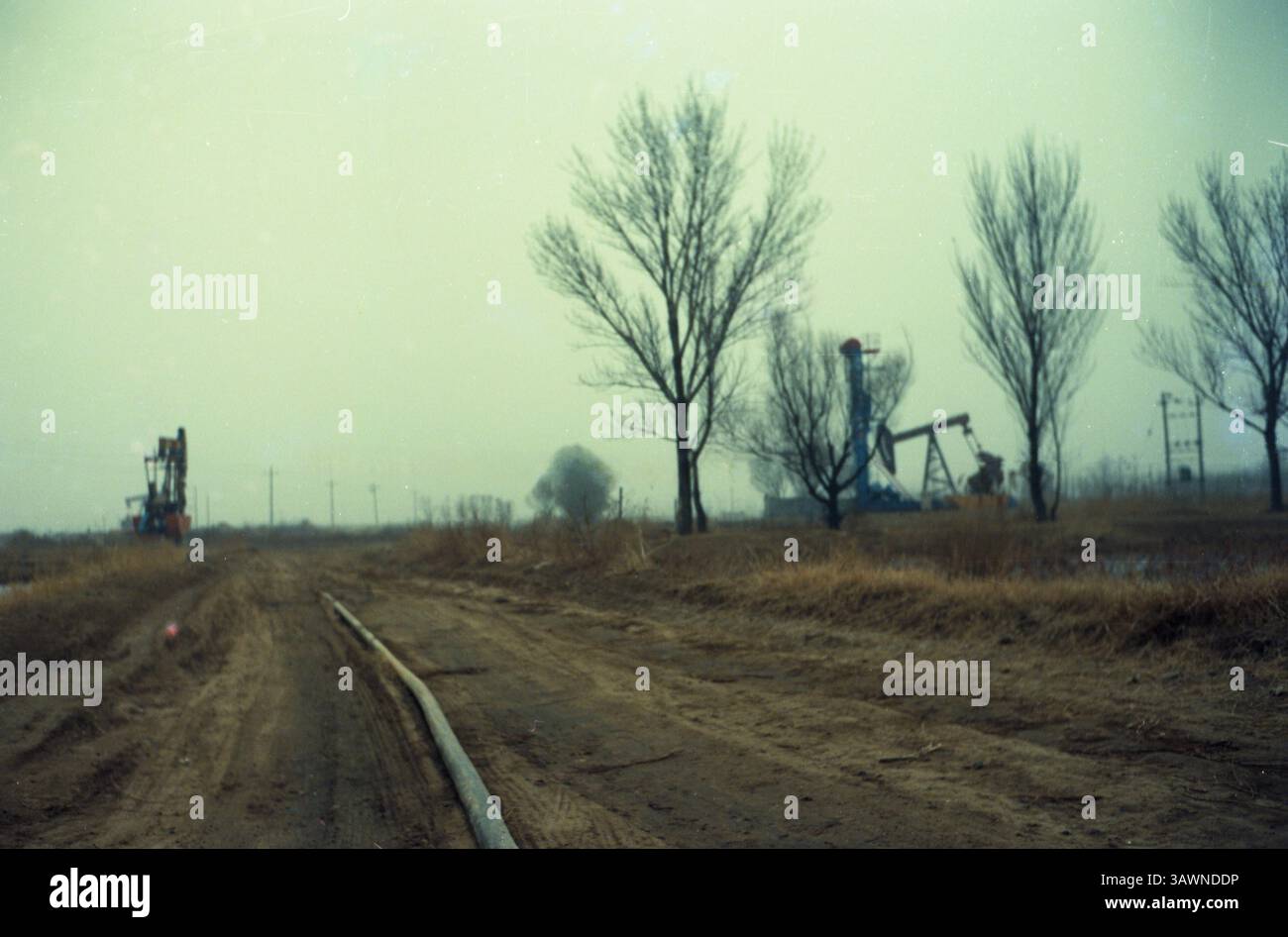 Oil extraction at dawn in a quiet rural landscape with silhouettes of ...
