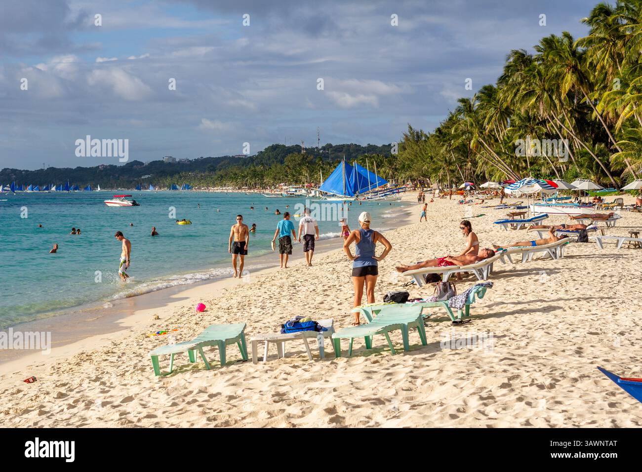 Visitors enjoy bathing and lounging along the coconut tree-lined White ...
