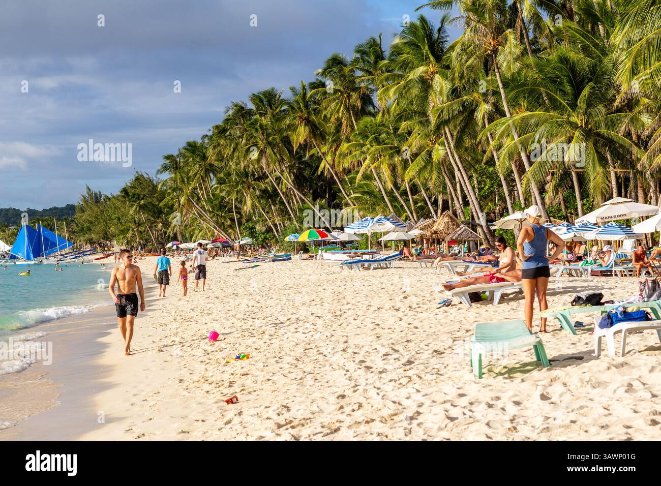 Visitors enjoy bathing and lounging along the coconut tree-lined White ...