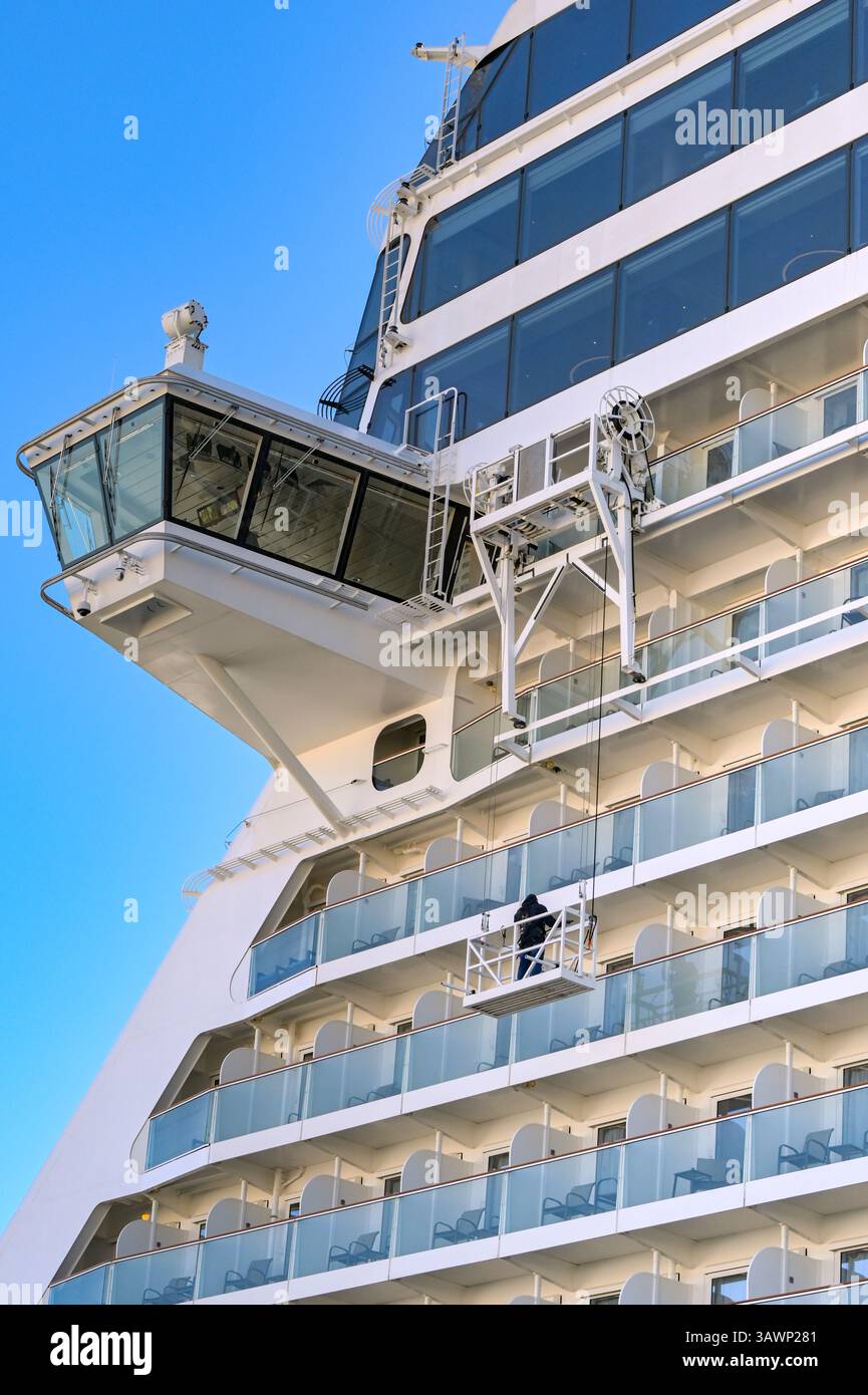Lisbon, Portugal - 13 January 2025: Crew member standing on a cradle platform hanging over a ...