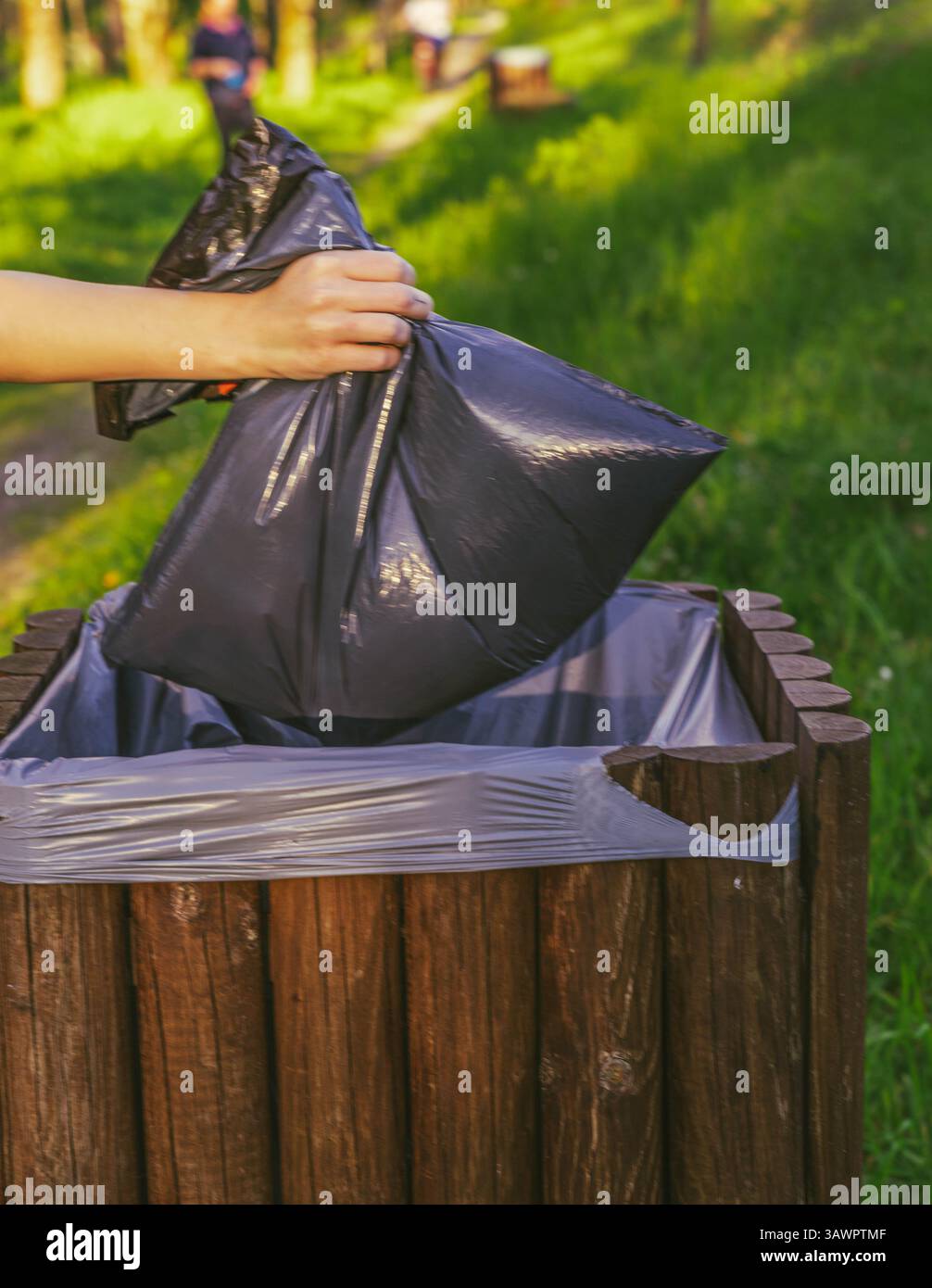 Female hand throwing trash bag in park bin Stock Photo - Alamy