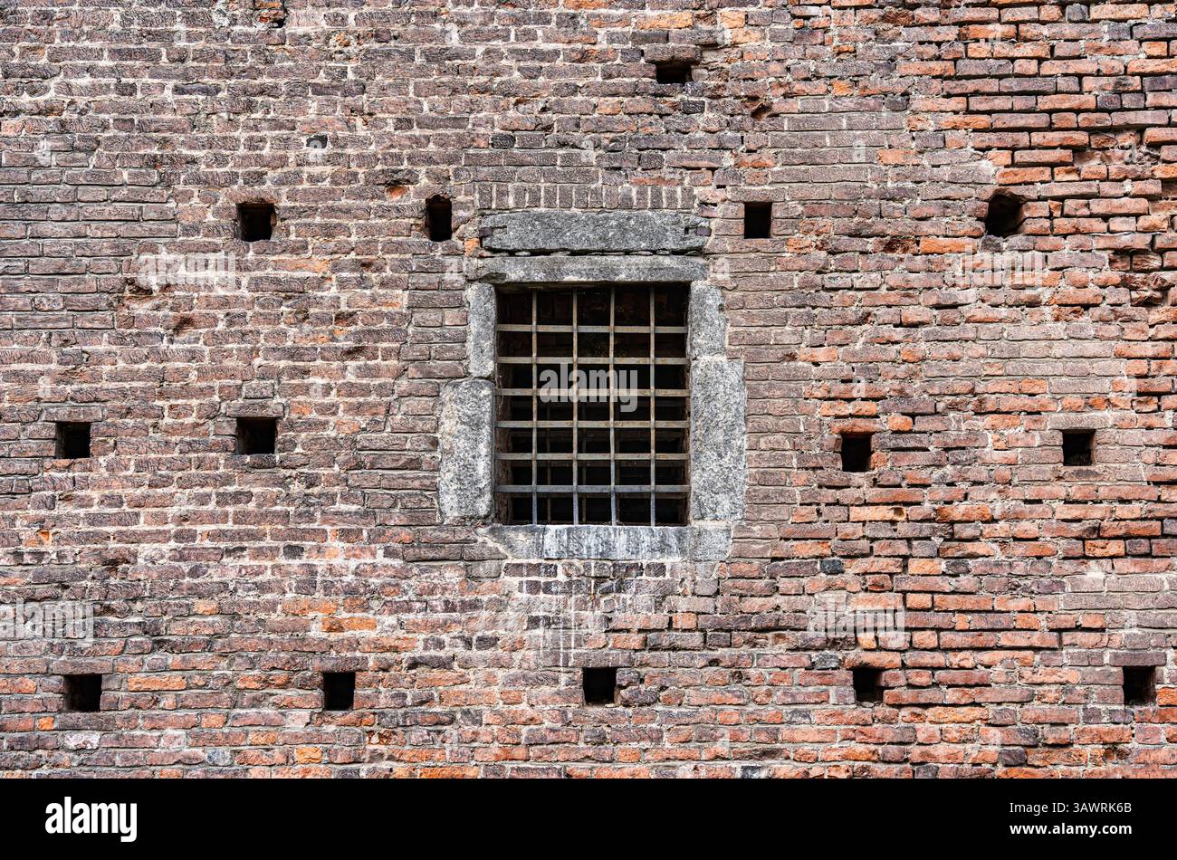 A close-up view of a window on a medieval brick wall, protected by a ...