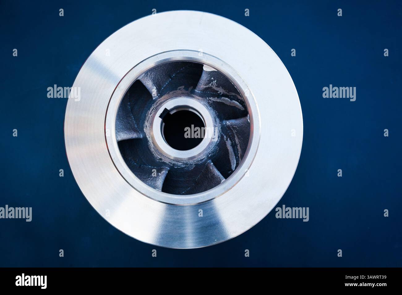 New bronze impeller on a dark blue background, top view Stock Photo - Alamy