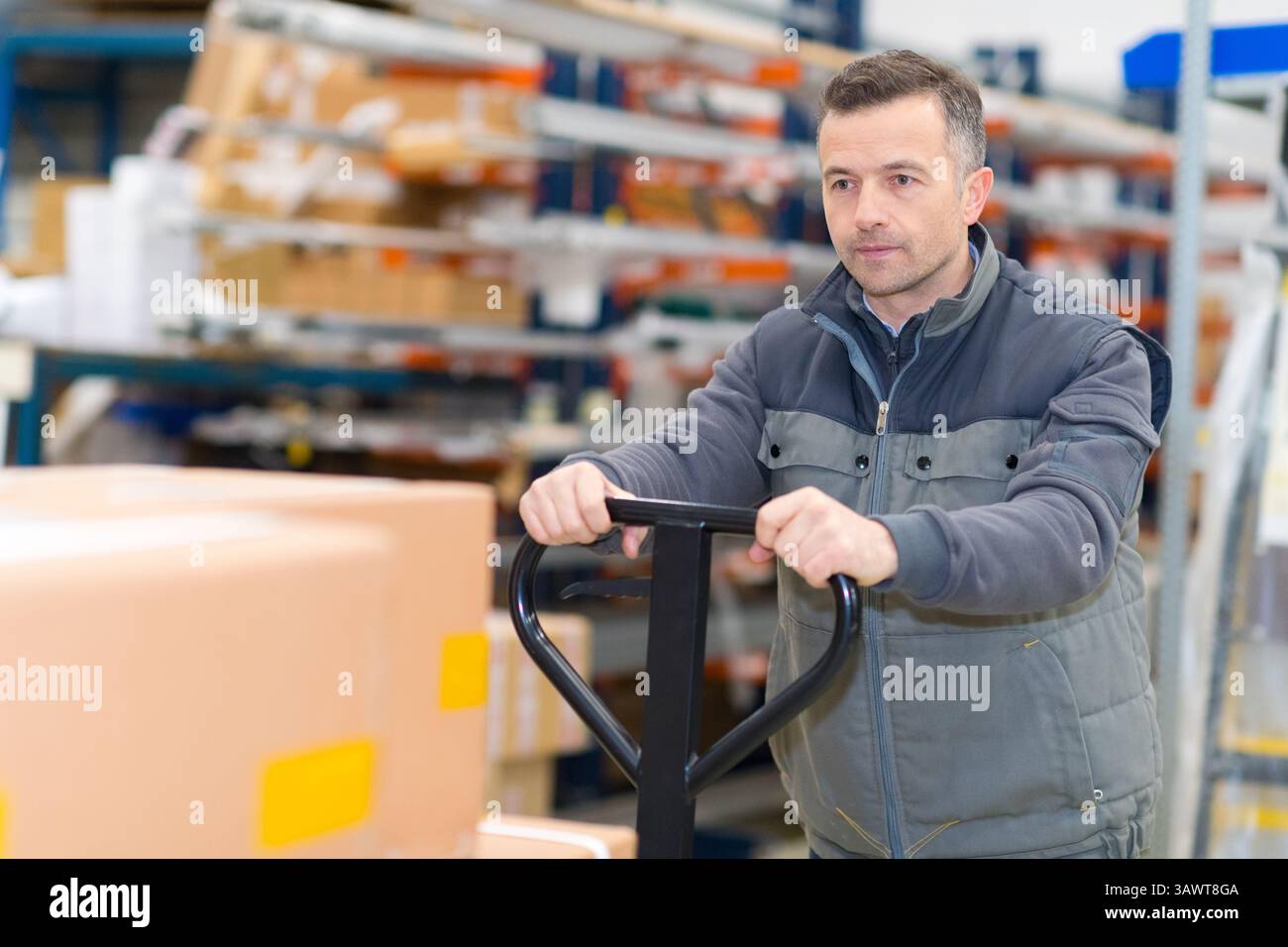 porter carrying boxes in a warehouse Stock Photo - Alamy