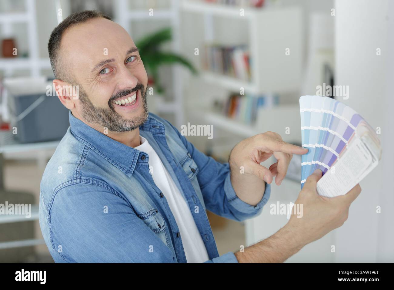 man pointing towards paint colour sample and laughing Stock Photo - Alamy