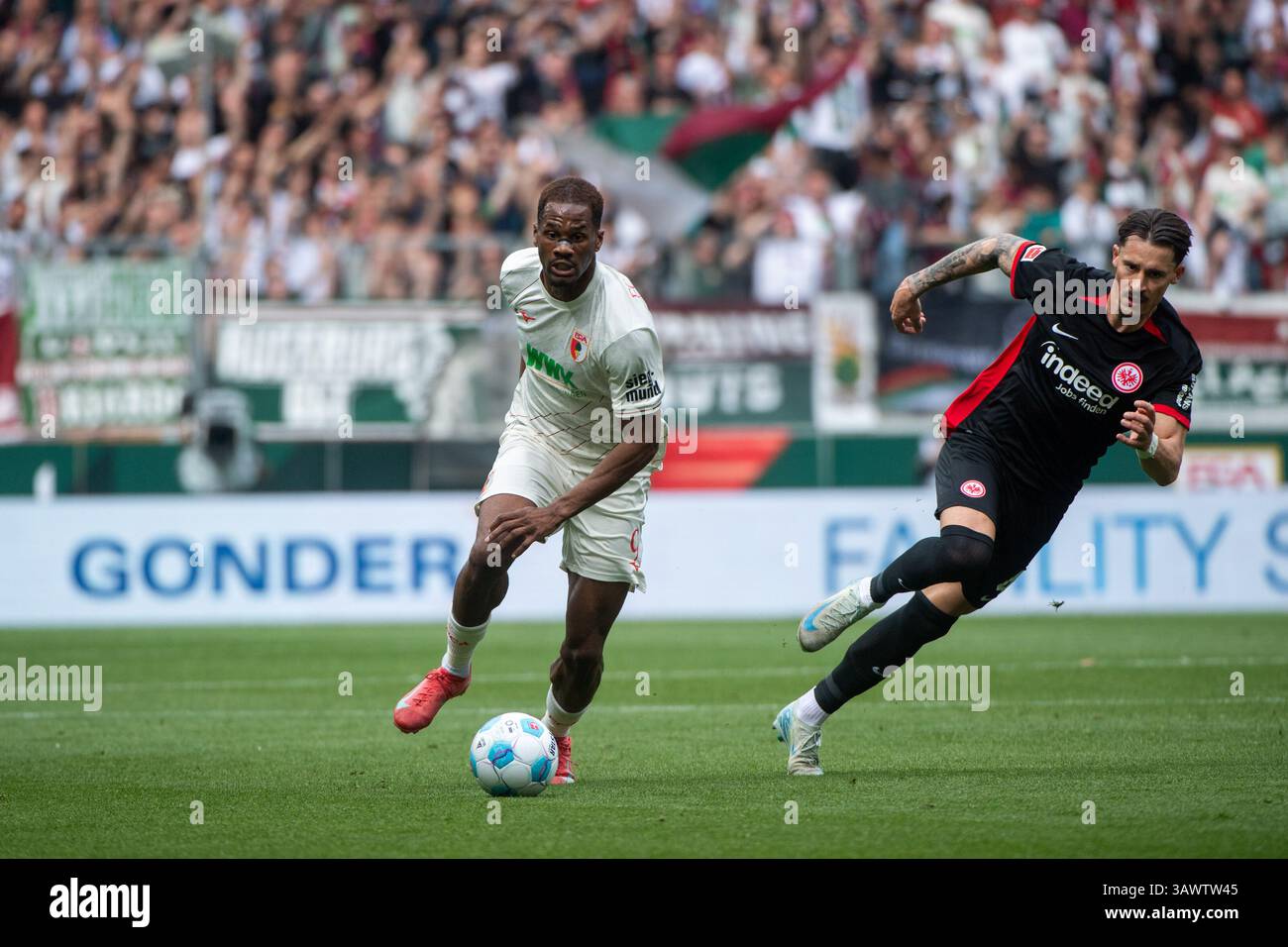 Samuel Essende (FC Augsburg, #09) im Zweikampf mit Robin Koch ...