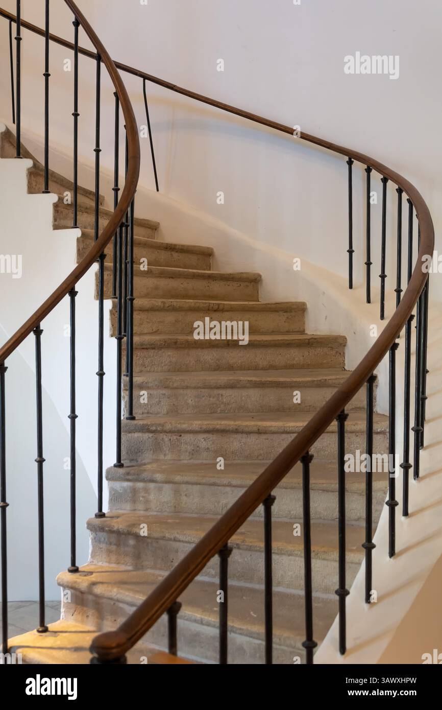 Spiral staircase with metal handrail and wooden handrail in an old ...