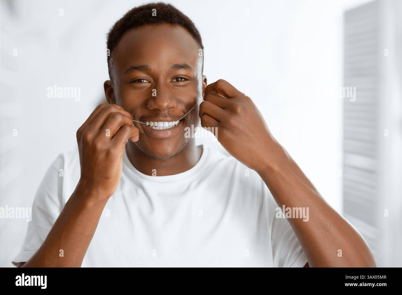 Happy African American Man Flossing Teeth Standing In Modern Bathroom ...