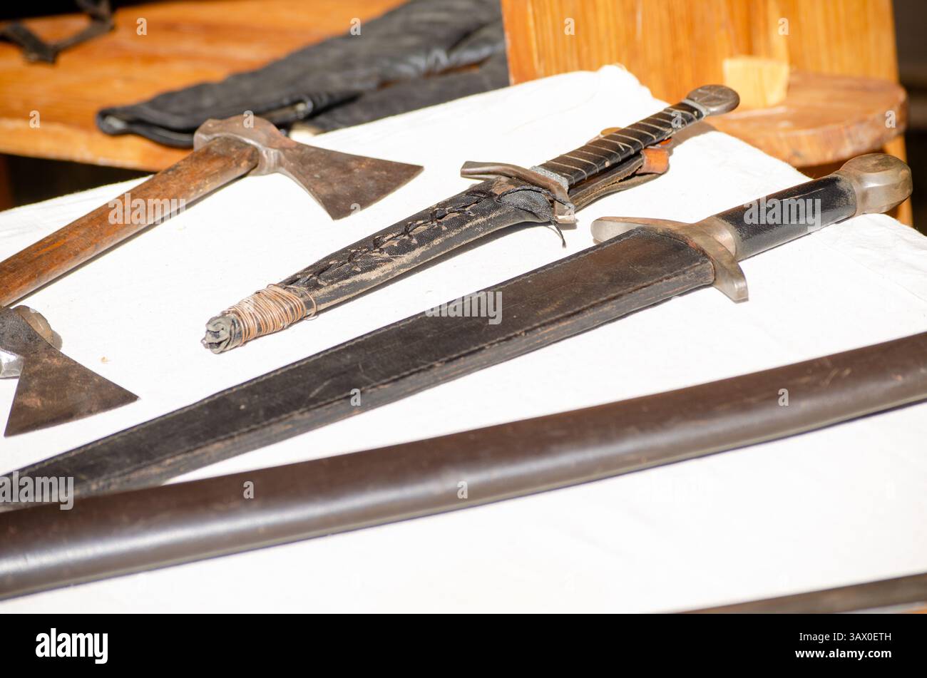 collection of historical axes and daggers laid out in a historical ...