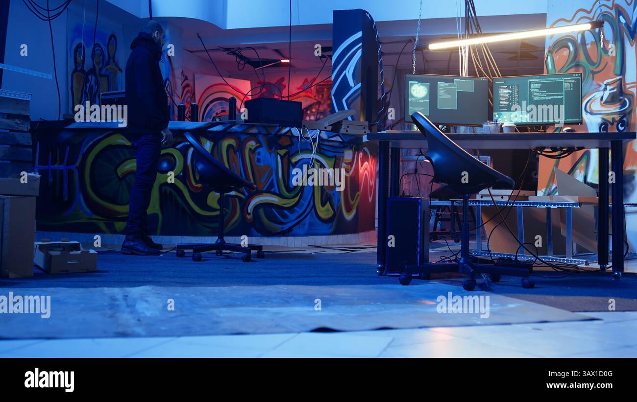 Hacker arriving in underground base, looking at spray cans in ...