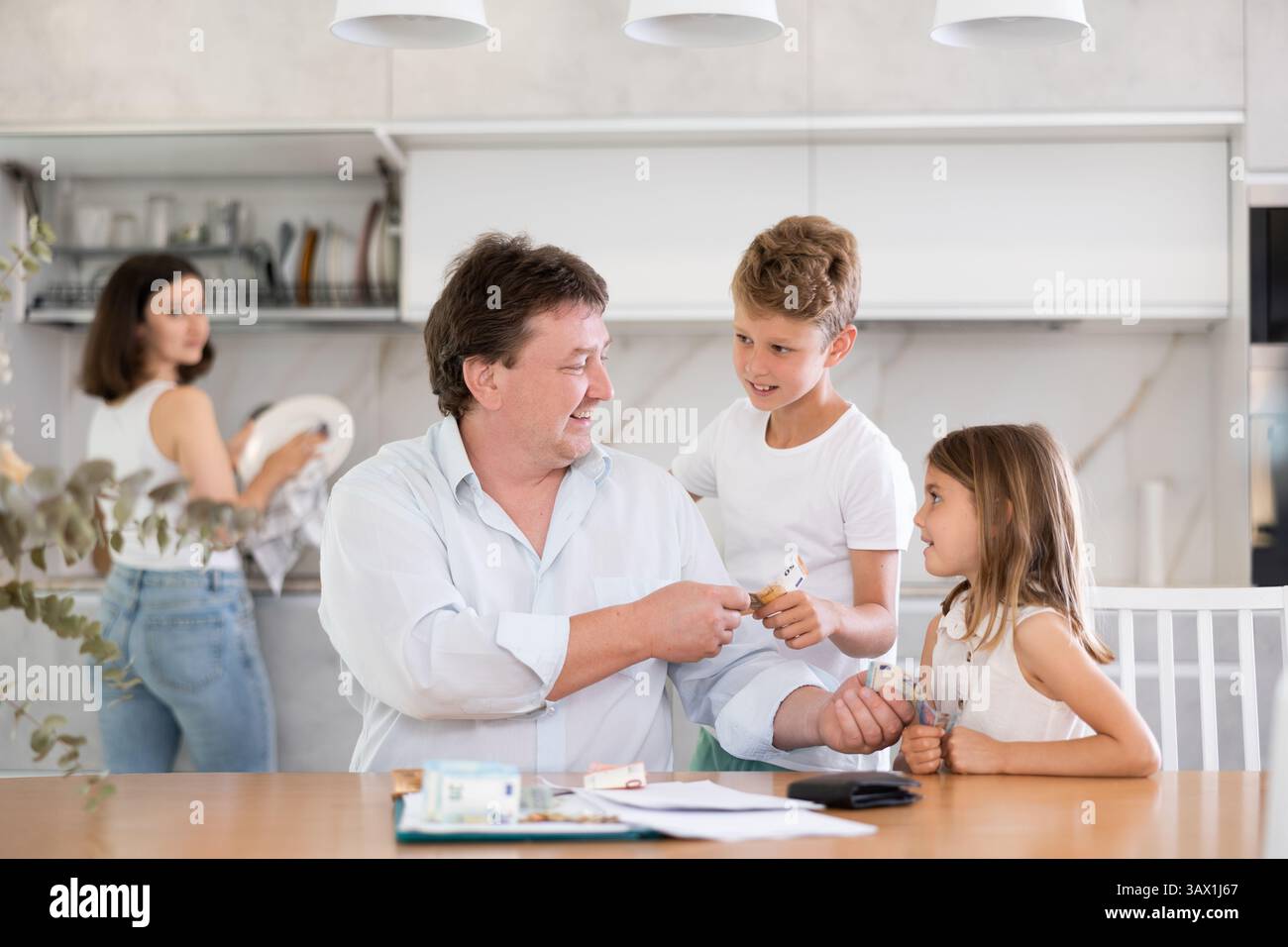 Father gives pocket money to children and wife Stock Photo - Alamy