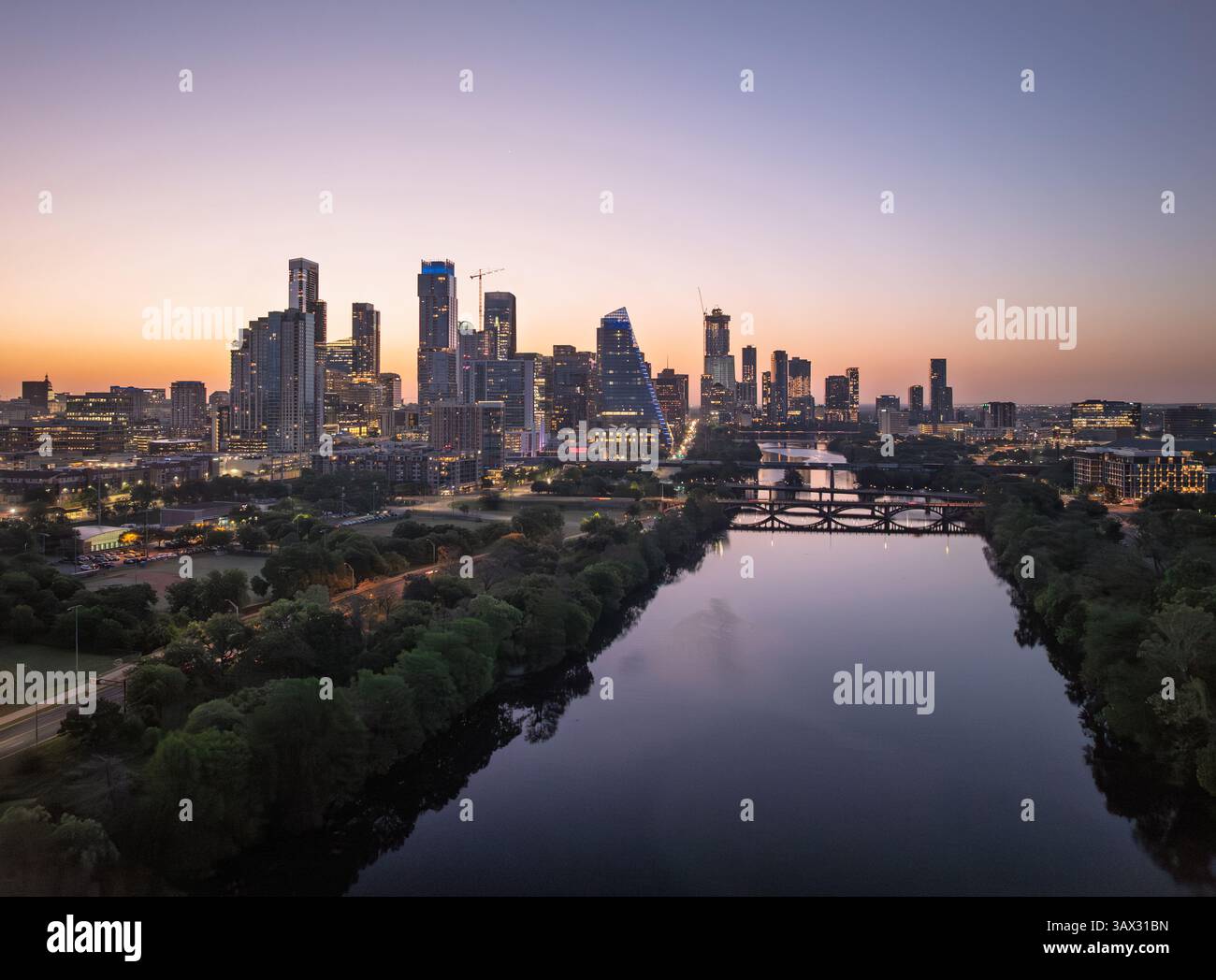 Brilliant orange and red sky behind the illuminated city skyline of ...