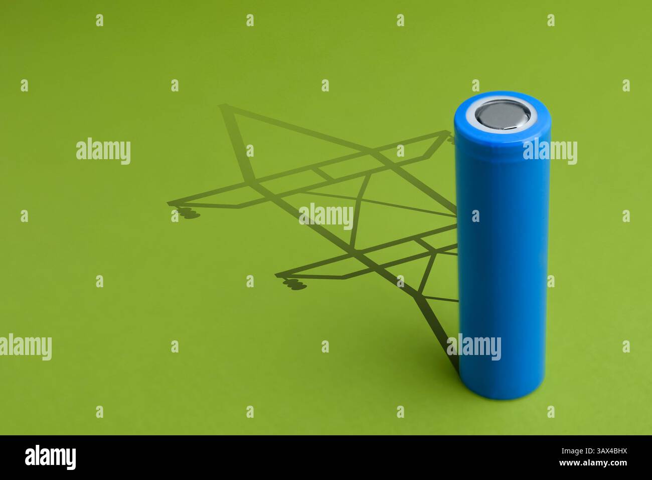 Alkaline battery with shadow in shape of high-voltage tower on green ...