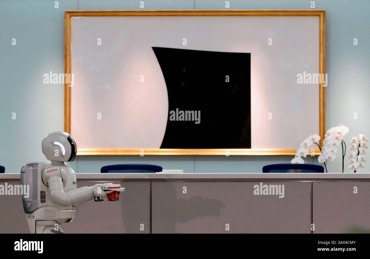 Honda Motor Co.'s humanoid robot ASIMO carries drinks across an office ...