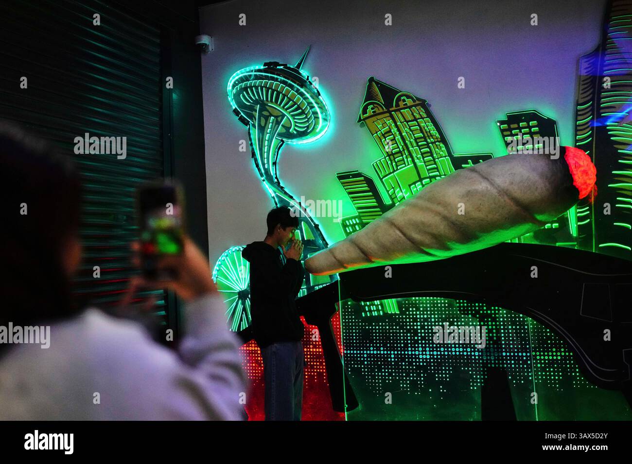 Gabriel Ramos poses for a photo in front of a large marijuana cigarette ...