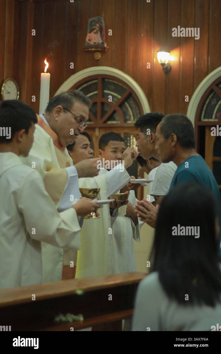 The priest and deacon administer Holy Communion to the faithful during ...