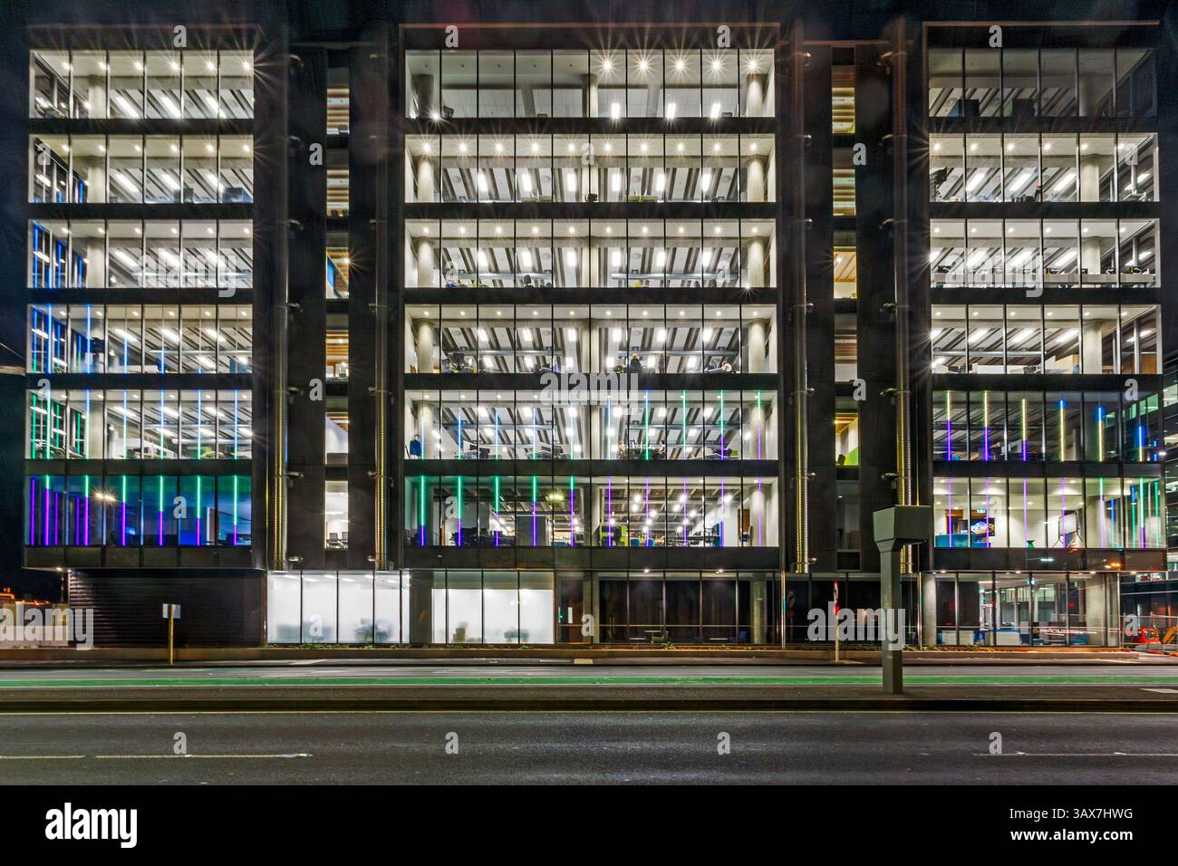 Modern office building illuminated at night showcasing colourful ...