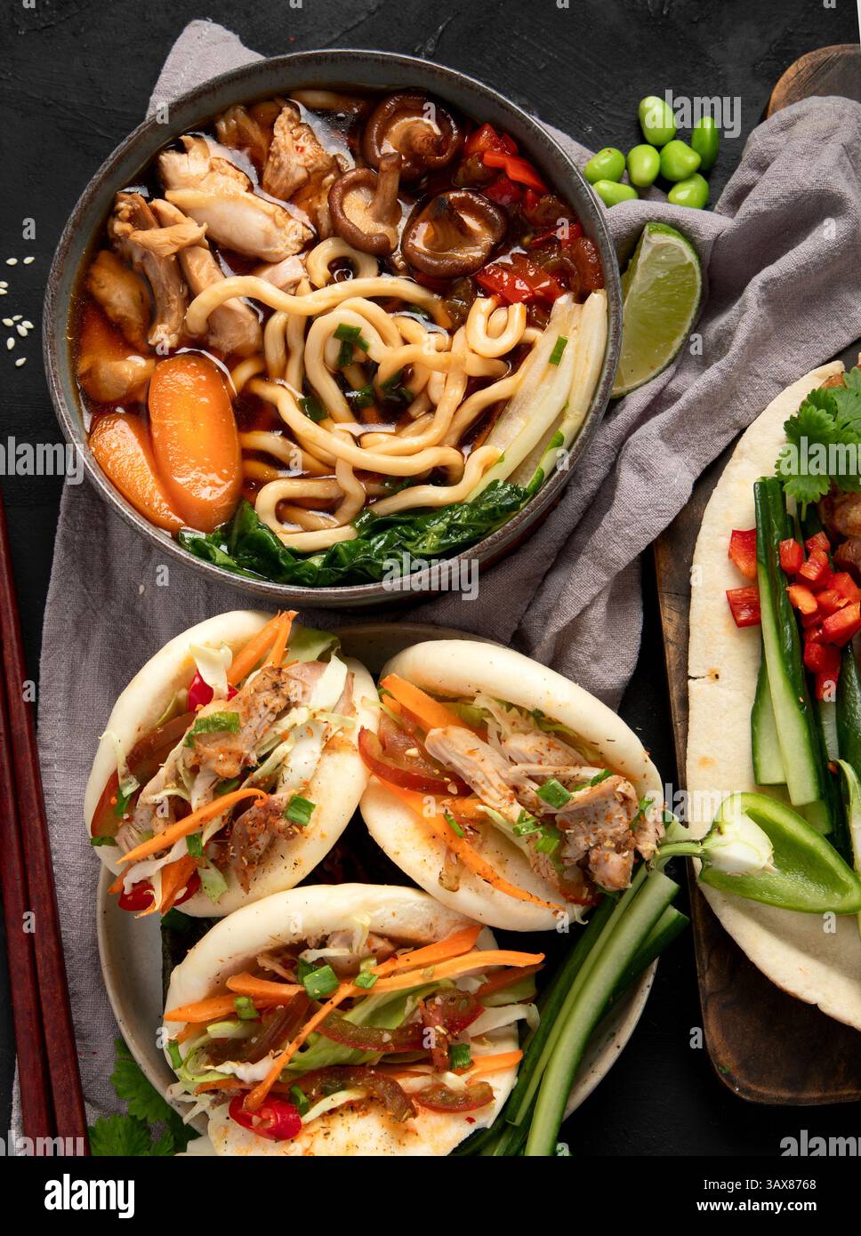 Set of Chinese dishes on dark background: sweet and sour duck, noodles ...