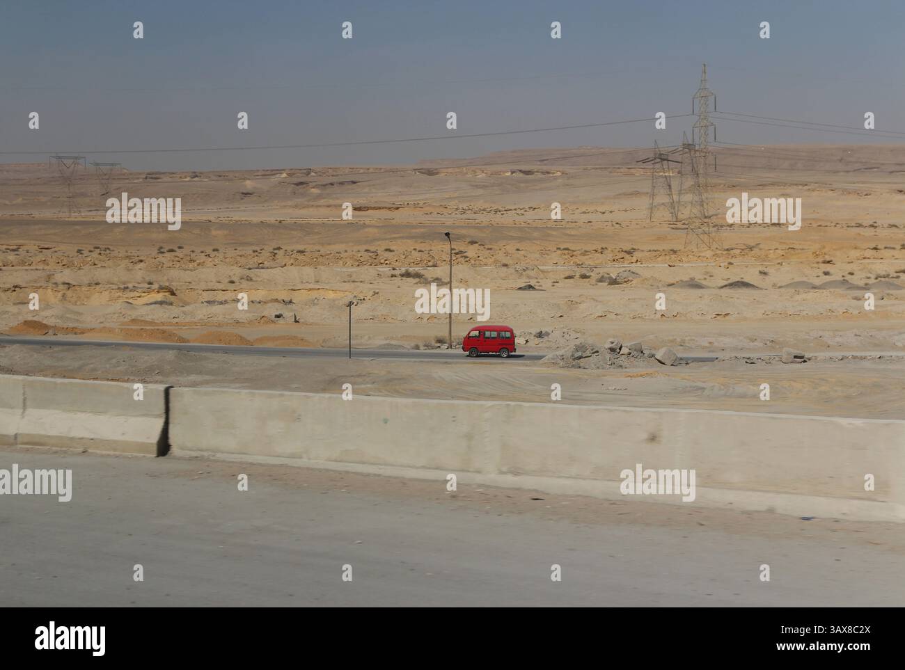 Desert scenery with a red van on the road trip from Hurghada to Cairo ...