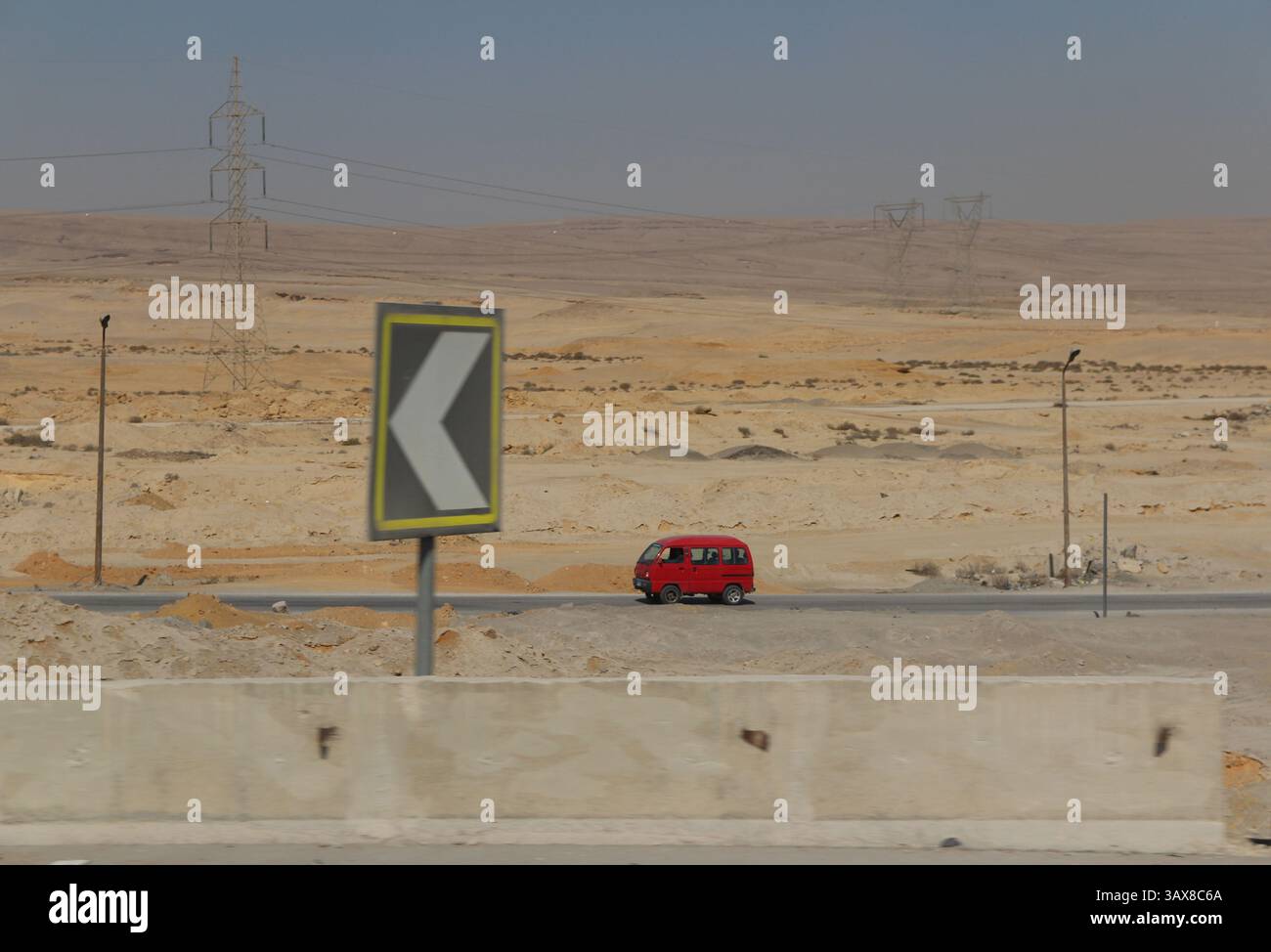 Desert scenery with a red van on the road trip from Hurghada to Cairo ...