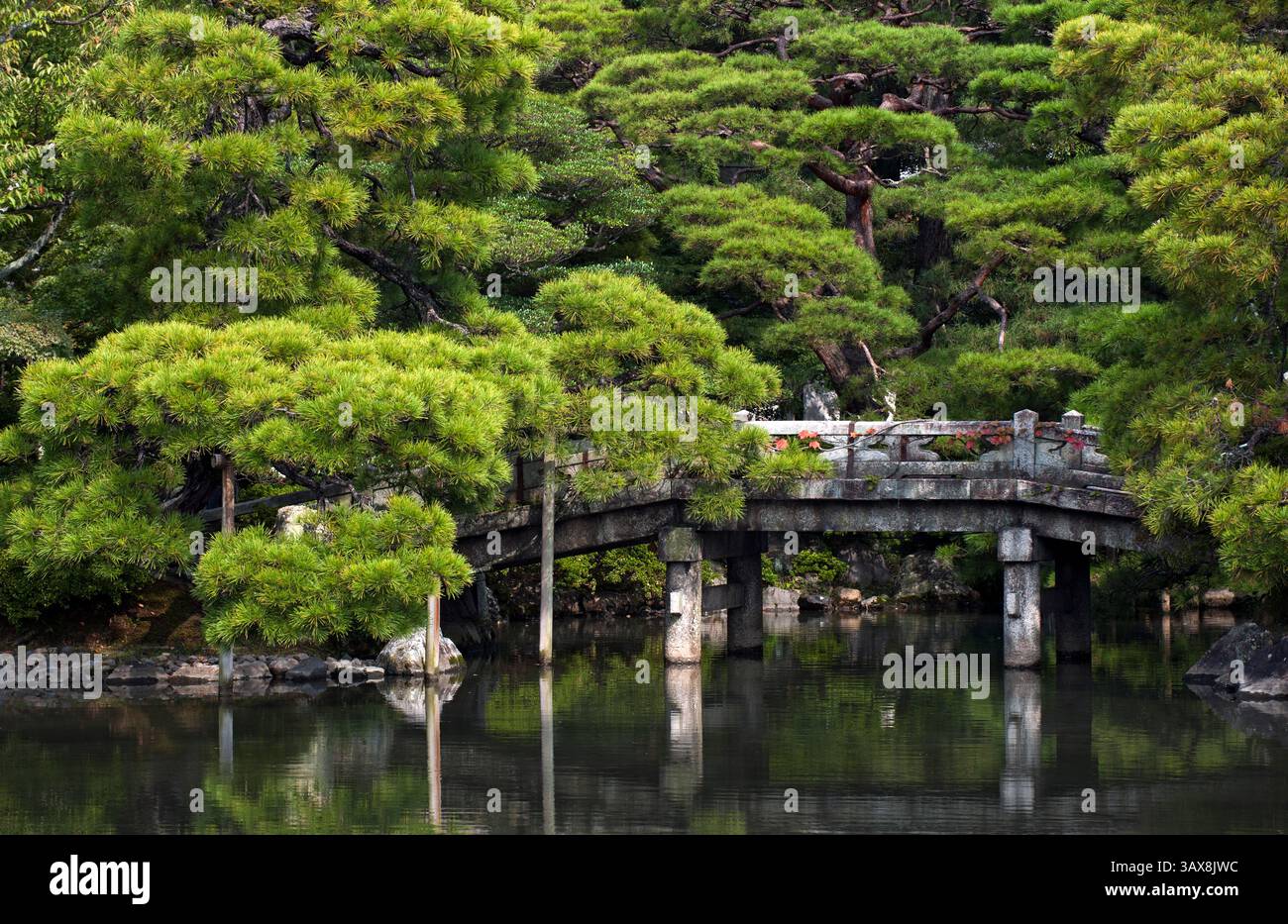 Stone bridge over the Oikeniwa Japanese landscape garden pond ...