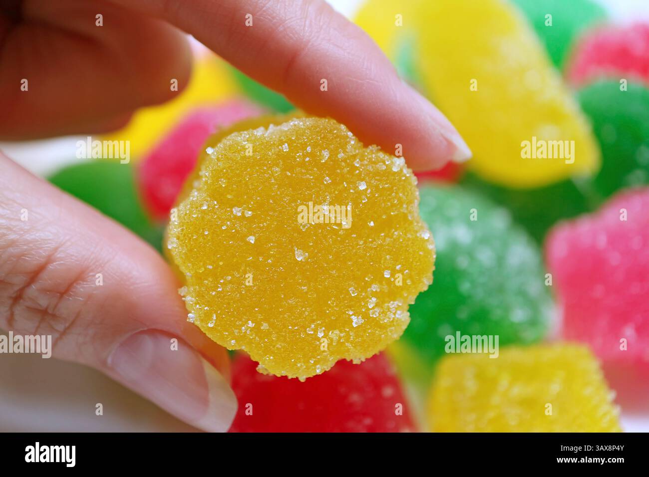 Hand Picking a Delectable Yellow Flower Shaped Soft Jelly Candy Stock ...