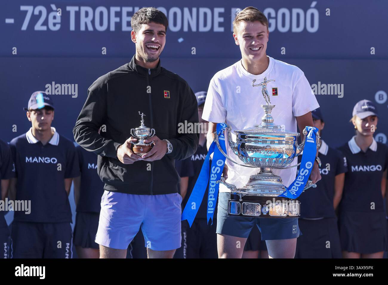 Holger Rune of Denmark poses with the winner's trophy with Carlos ...