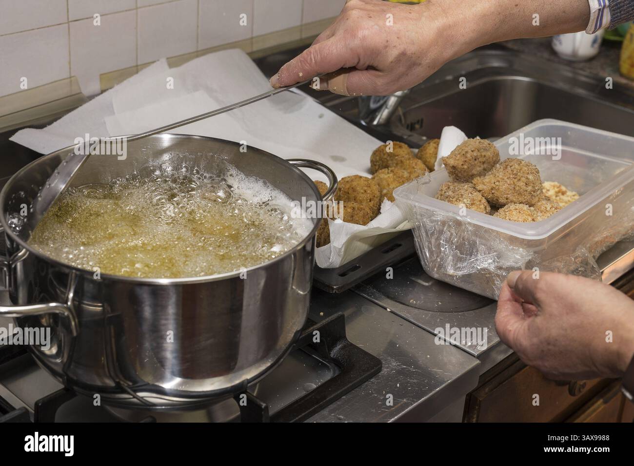 Chef frying food in flaming pan on gas hob in commercial kitchen Stock ...
