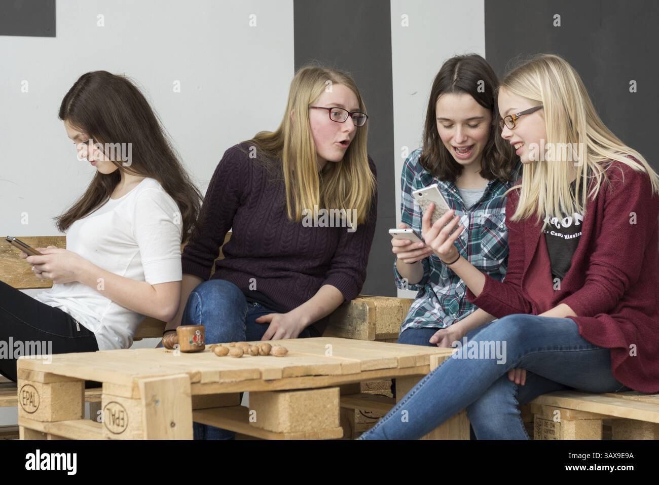 Female group of teenagers talking on mobile phones and showing ...