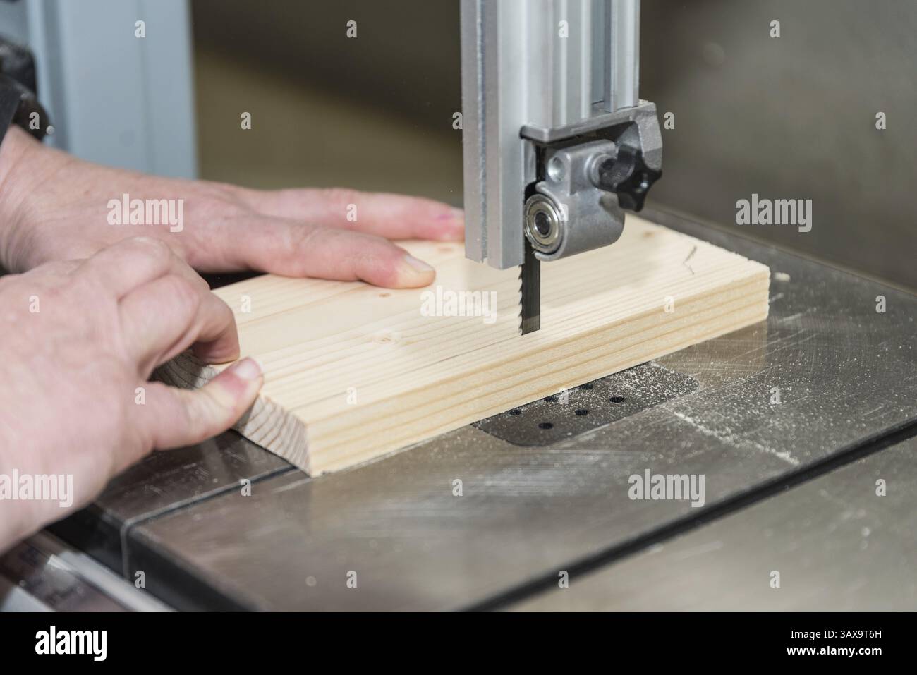 Carpenter saws softwood in wood workshop with band saw - Joinery Stock ...