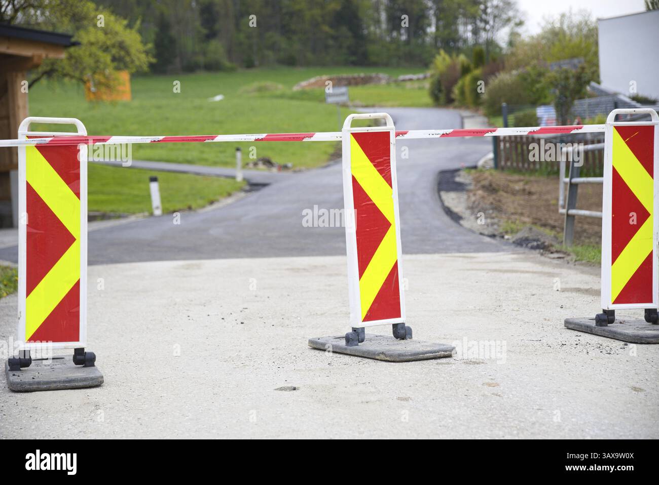 Road closure with barrier tape and mobile signs on construction site ...
