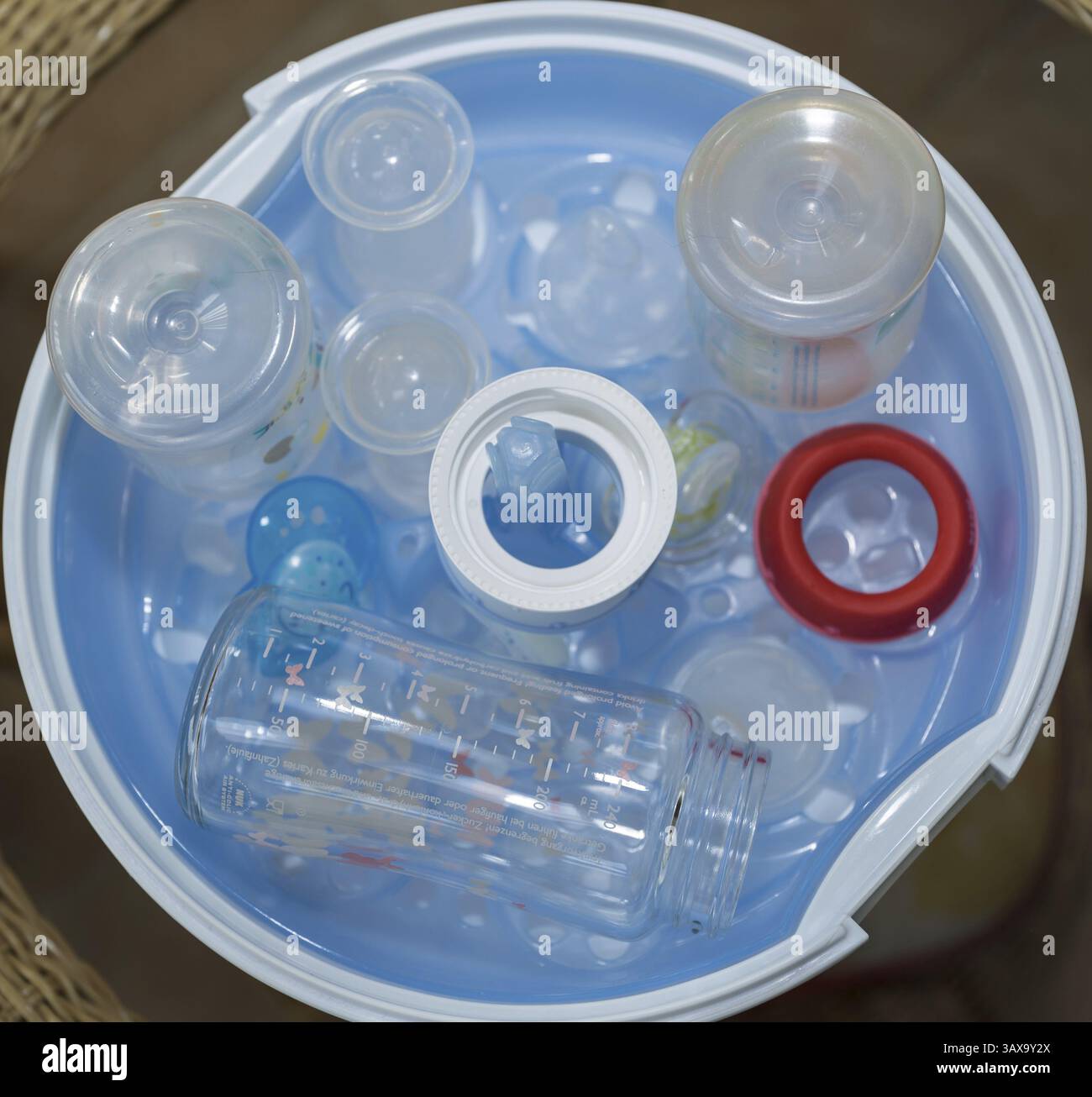 Cleaning baby bottles in a steam steriliser - close-up sterilisation of ...