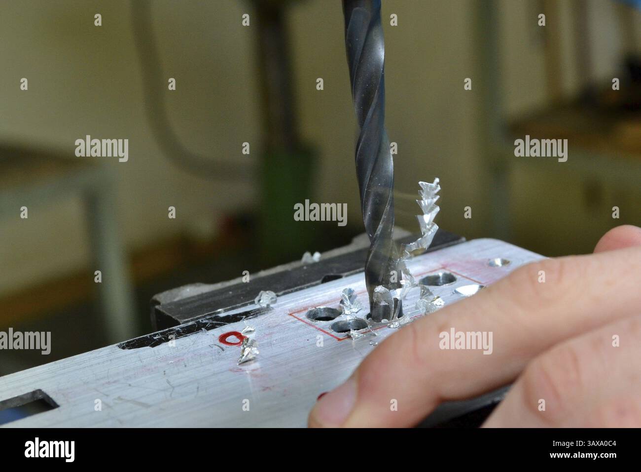 Metal holes are drilled with a drill in the workshop Stock Photo - Alamy