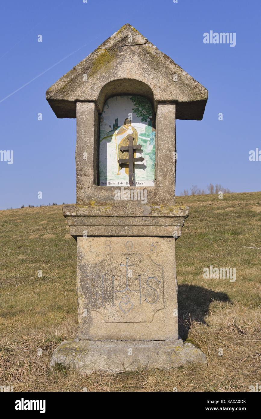 Old wayside shrine and stone prayer pillar with painting showing ...