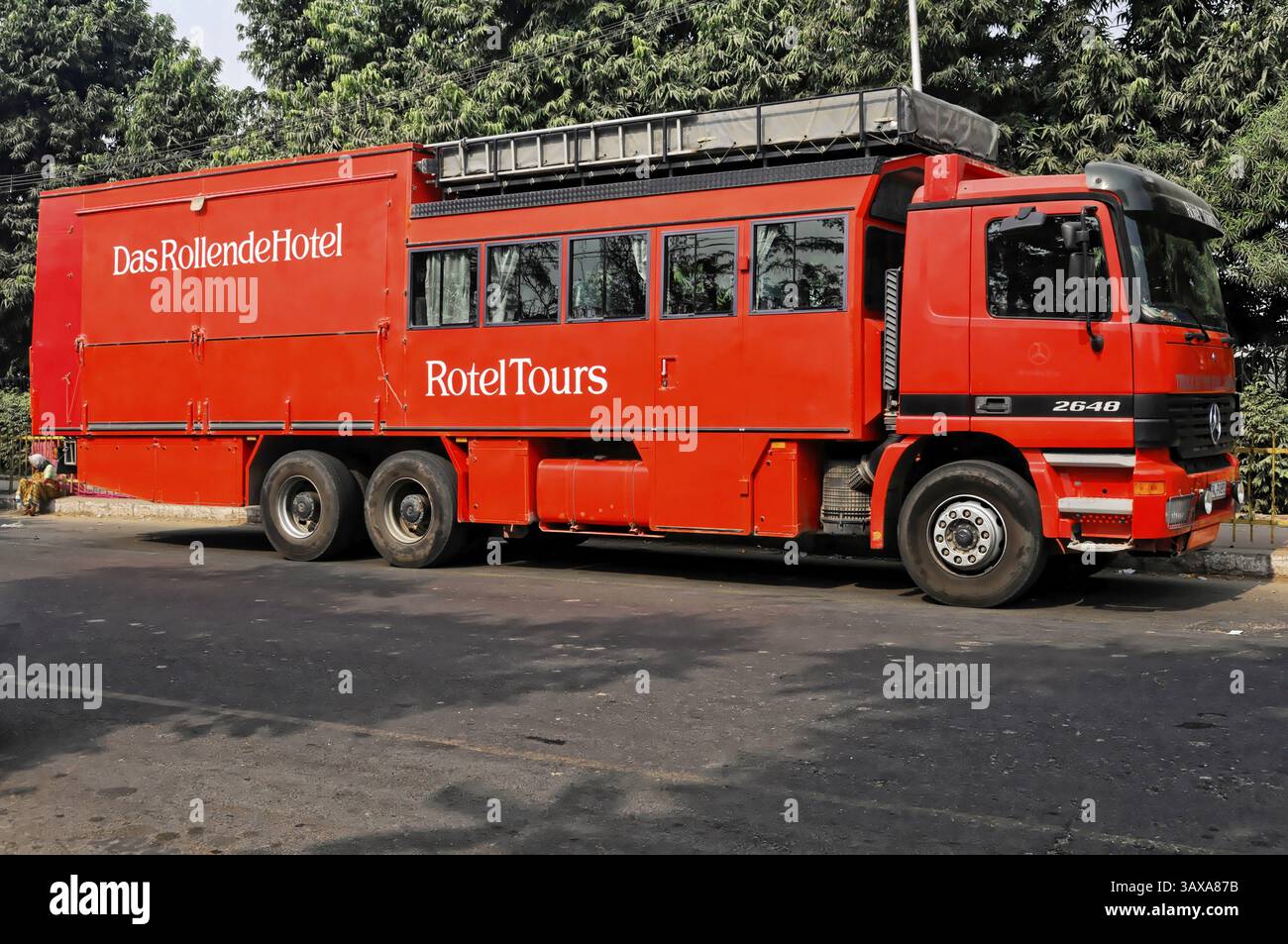Delhi, North India, Asia, A red coach with an inscription on a paved ...