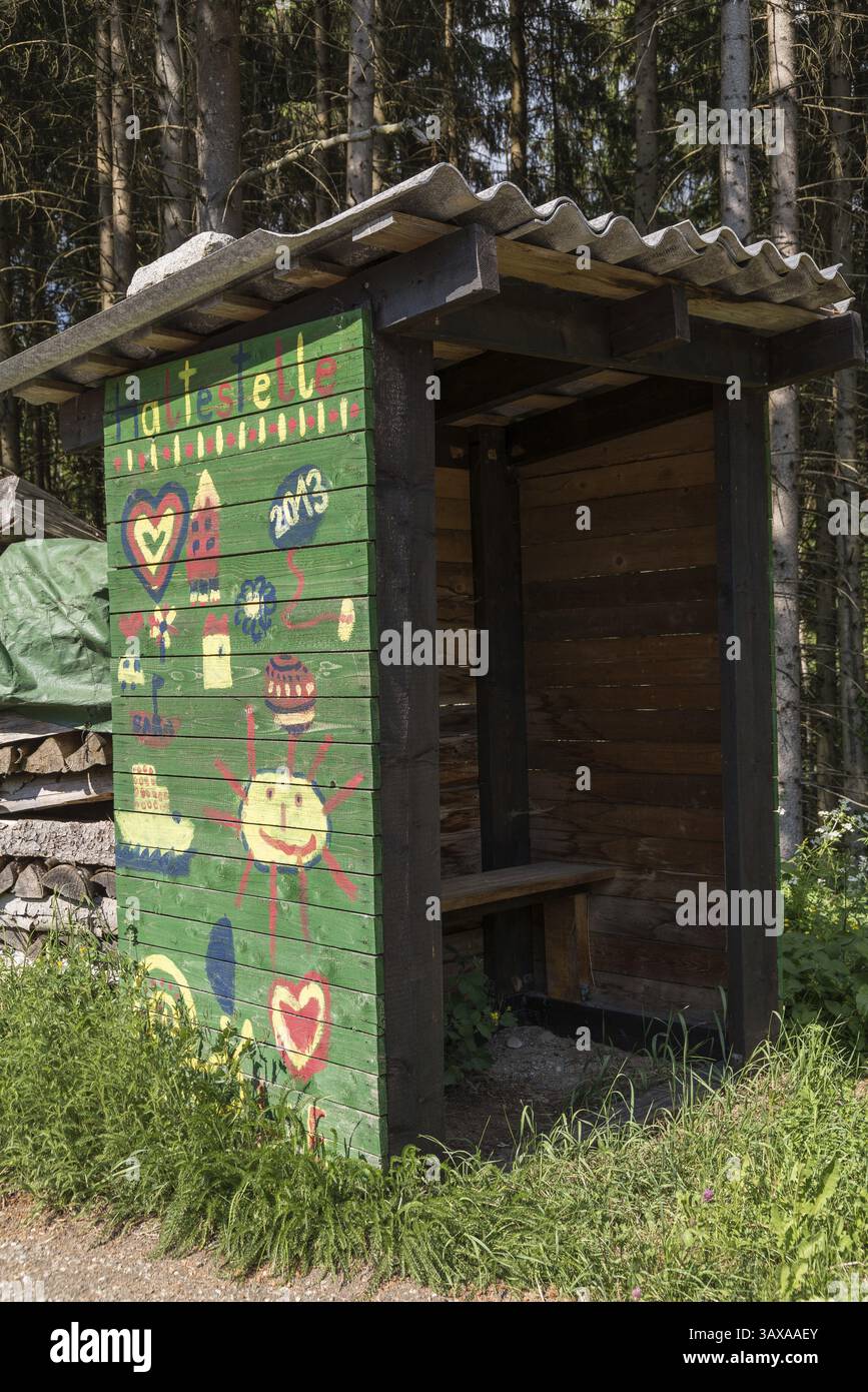 Bus stop painted by children at the edge of the forest - wooden hut and ...