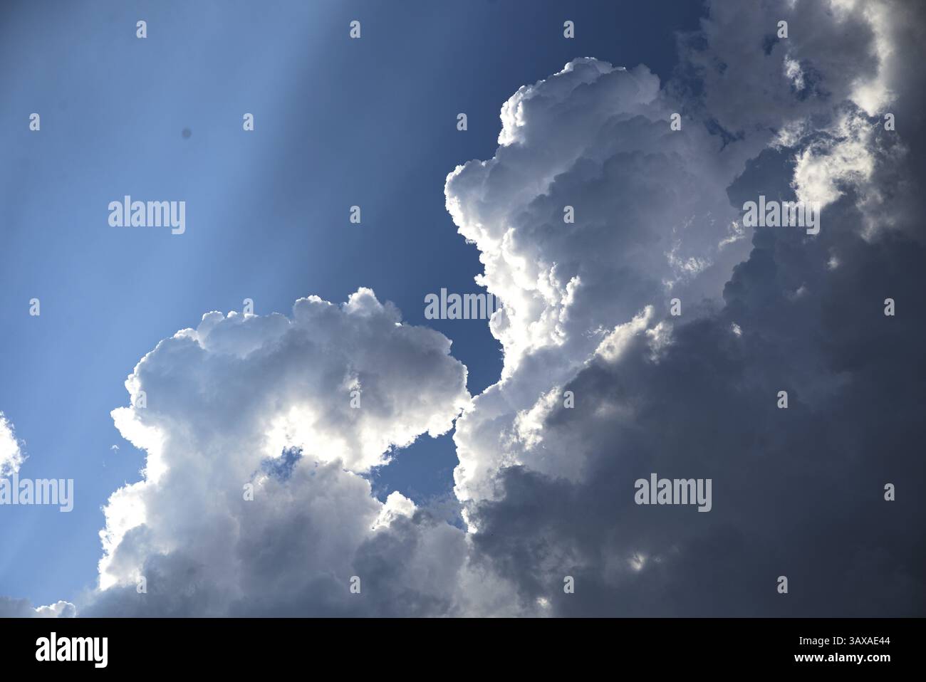 Rays of sunshine shine out between cumulus clouds and rain clouds ...