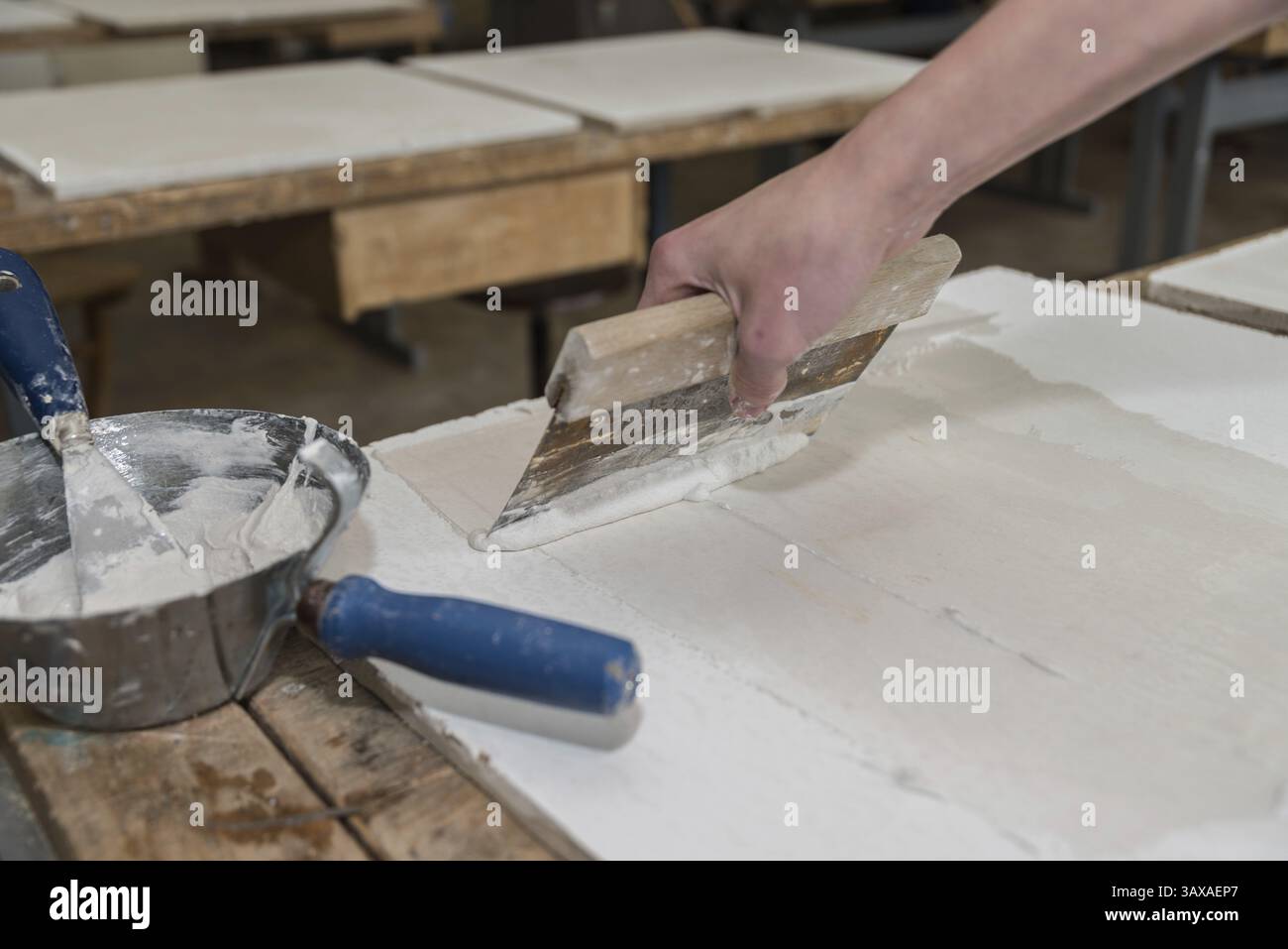 Construction worker applies levelling compound to plasterboard with a ...