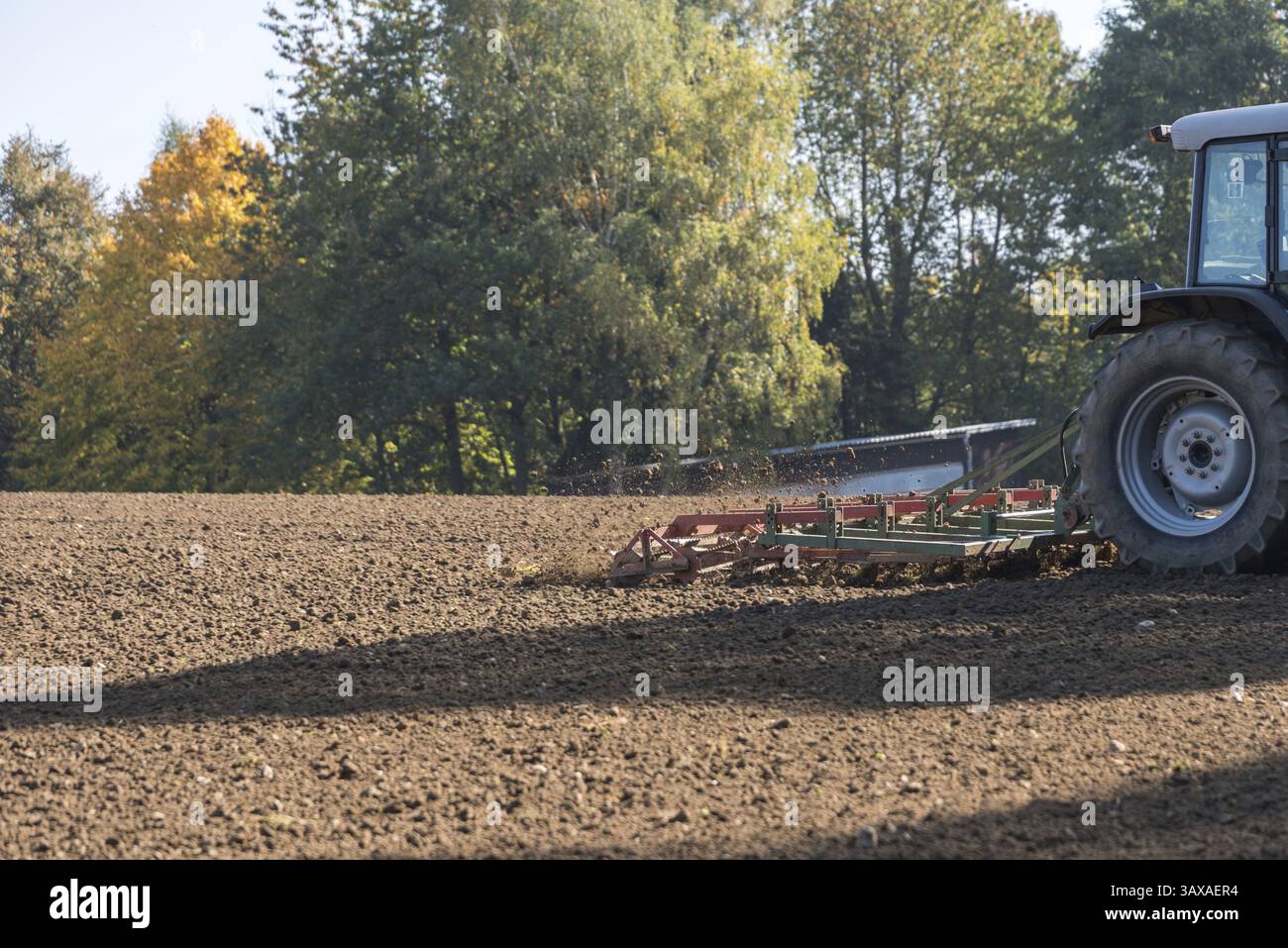 Bauer tilling the soil with tractor and harrow - Detail arable farming ...