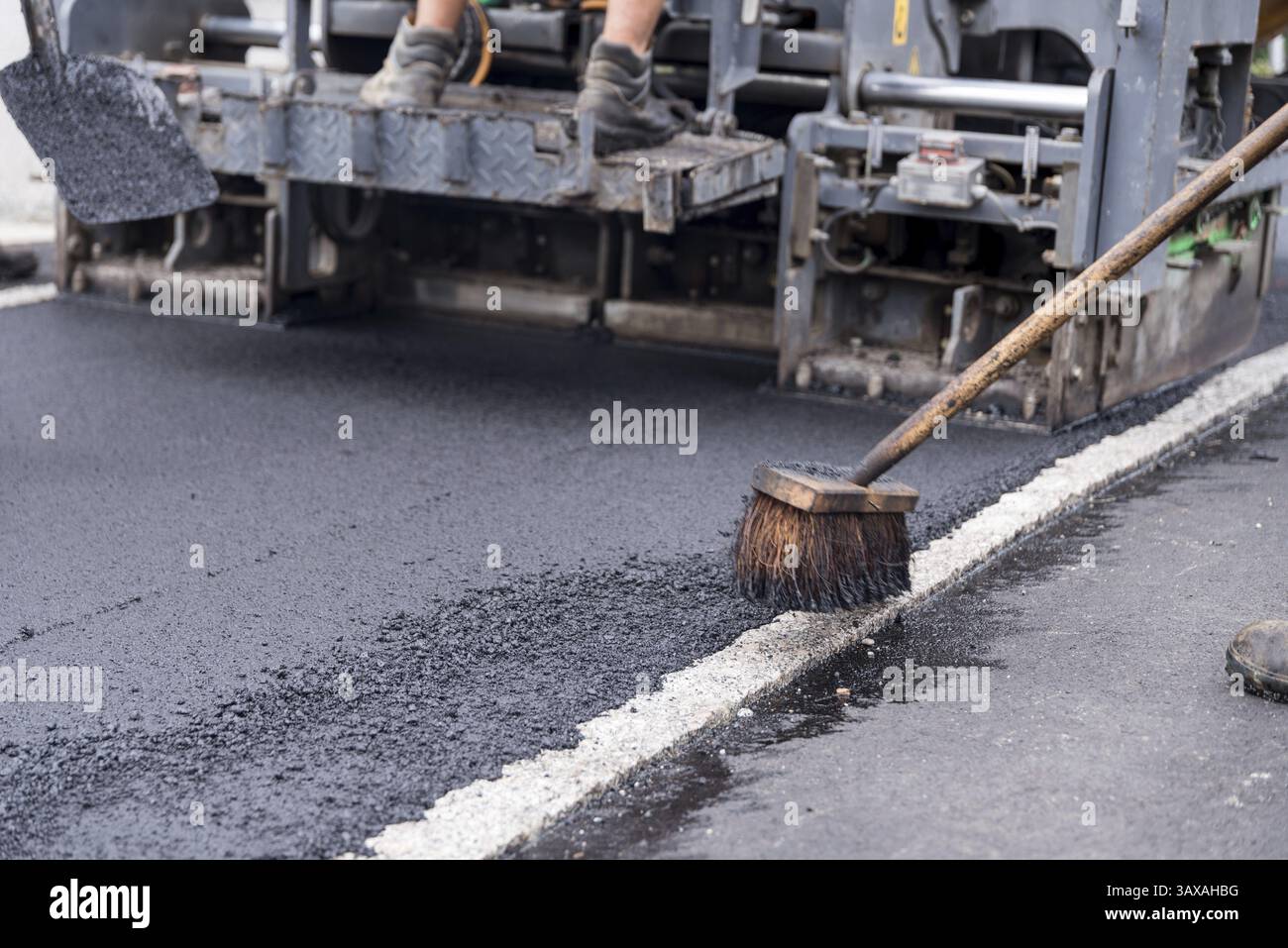 Asphalting a road with a construction machine - Road paver with sweeper ...