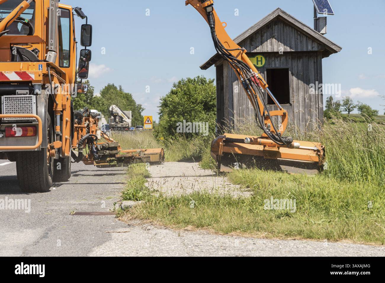 Mowing by the road maintenance service with a mower at the roadside ...