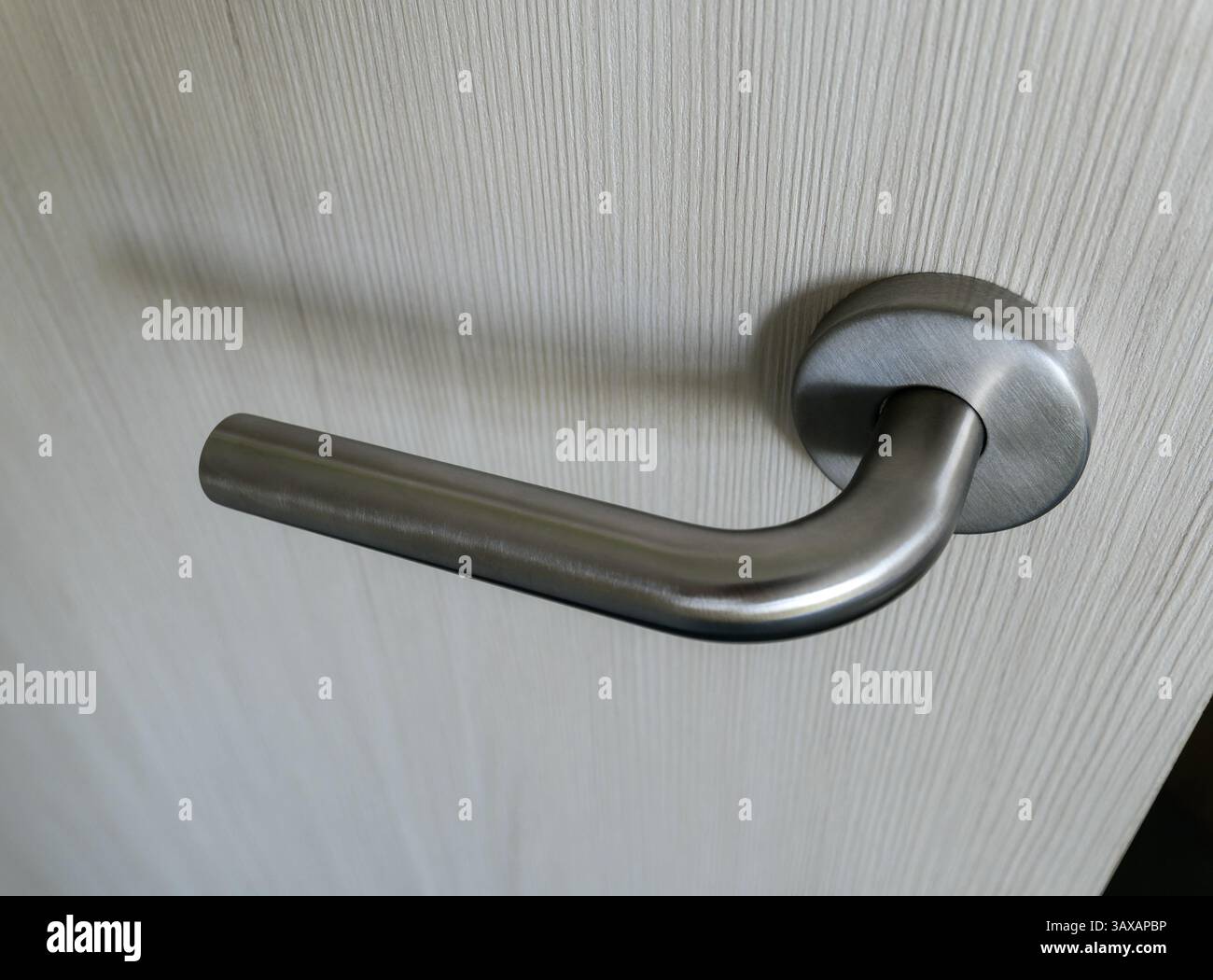 Stainless steel door handle on a light door close-up Stock Photo - Alamy
