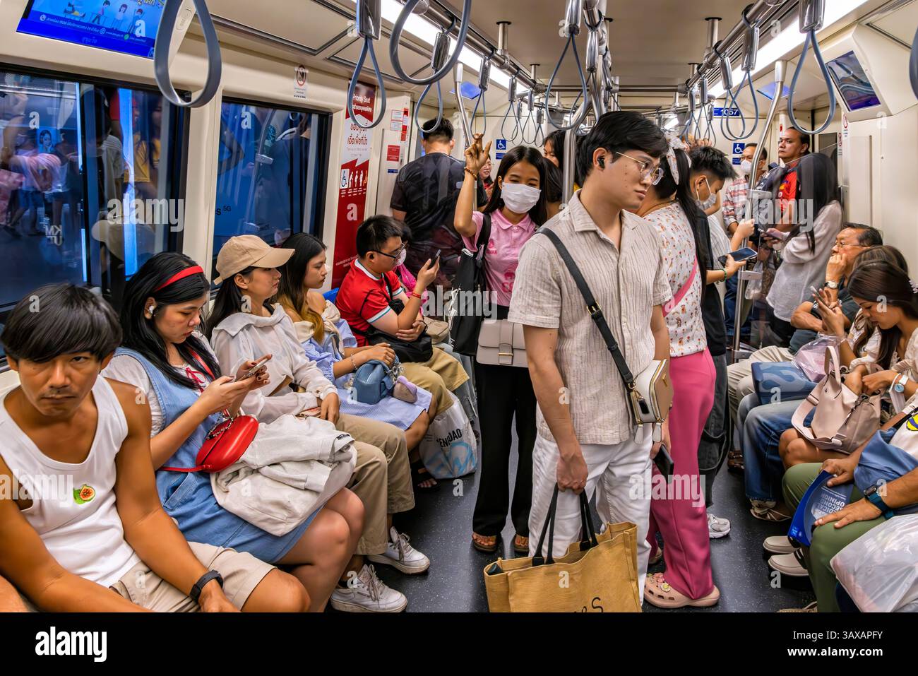 Passengers on crowded MRT underground train using mobile phones, Bangkok, Thailand Stock Photo ...